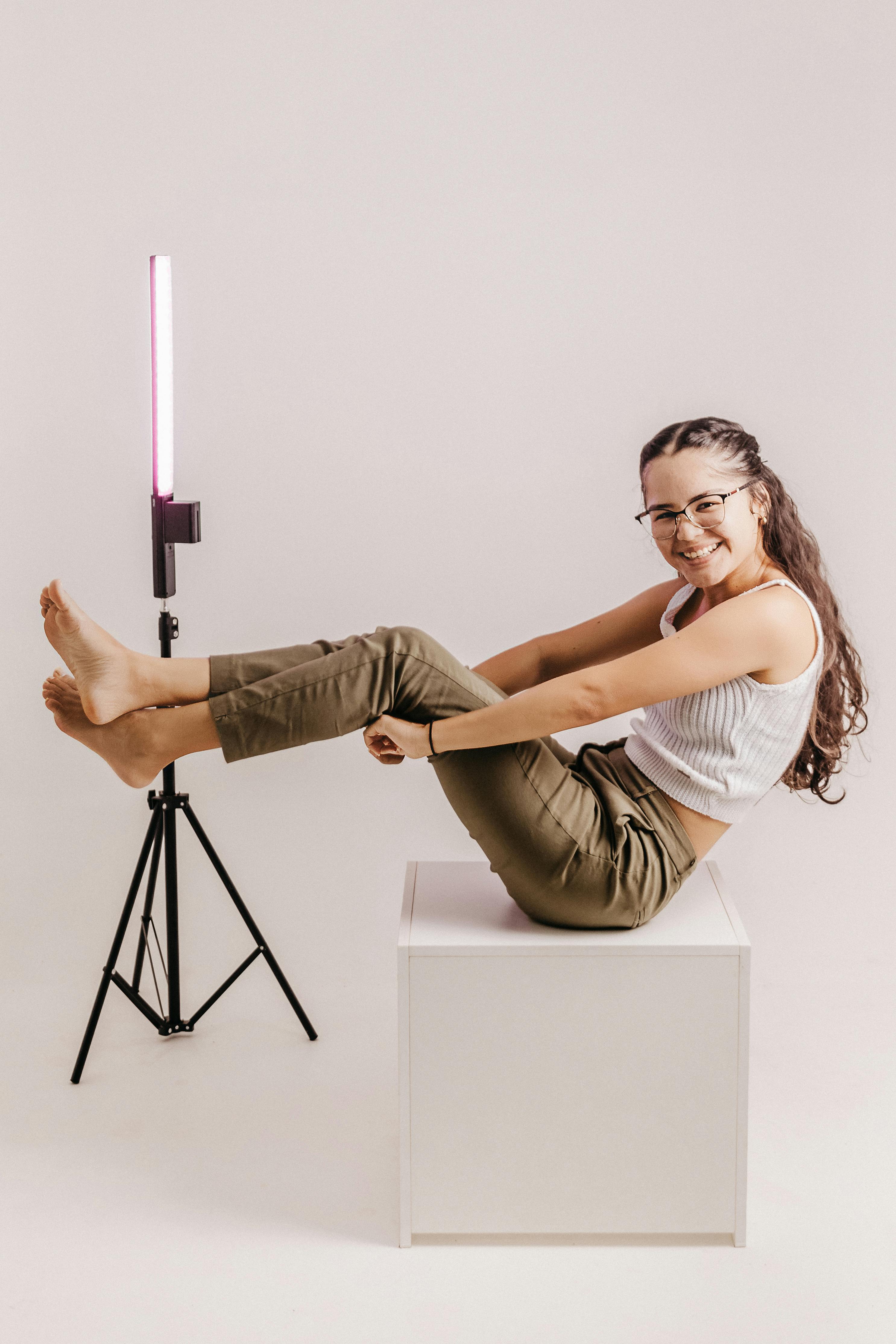Smiling Woman Sitting and Posing with Legs Raised · Free Stock Photo