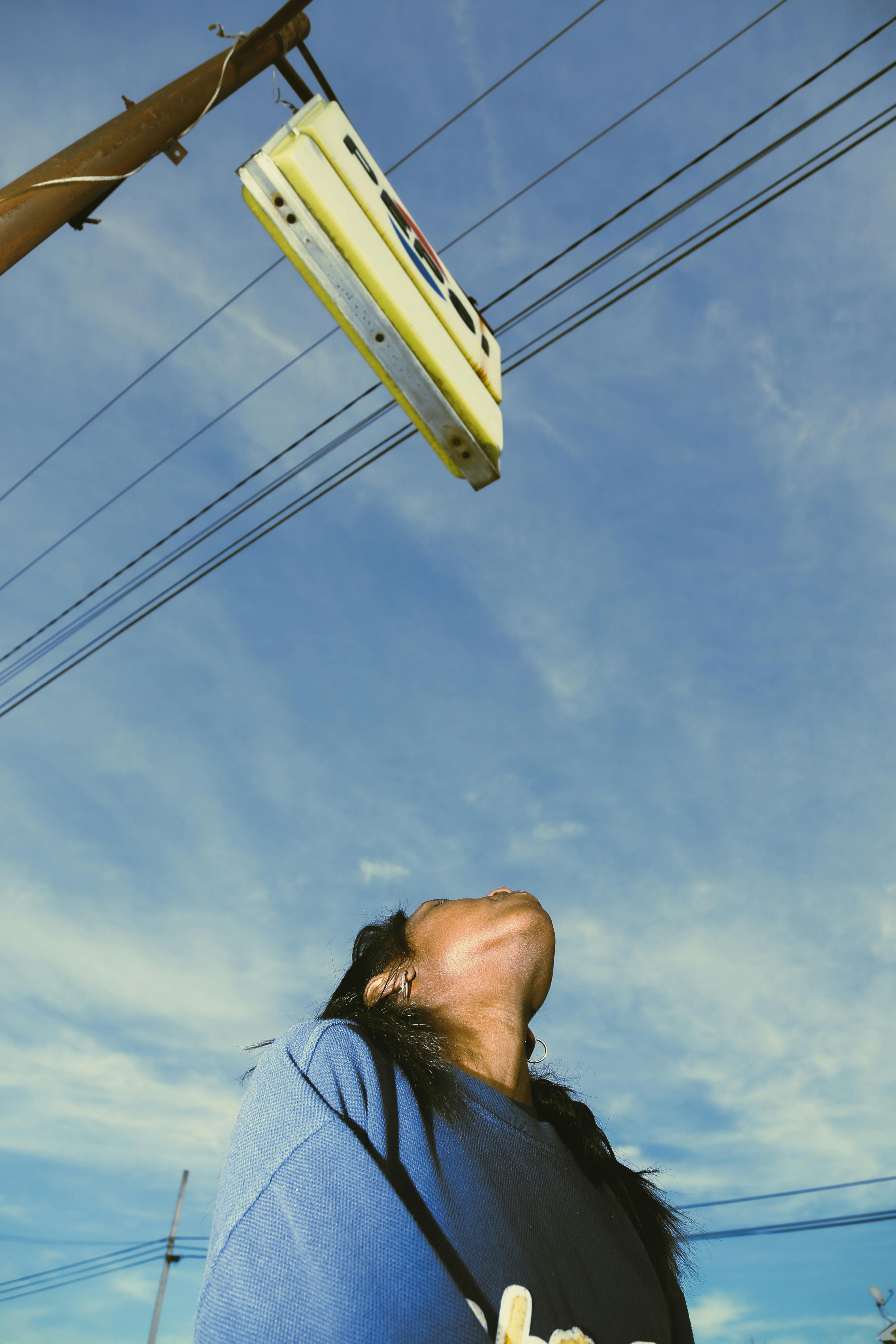 Passerby Looking Up at the Pepsi Sign and Overhead Power Lines · Free ...