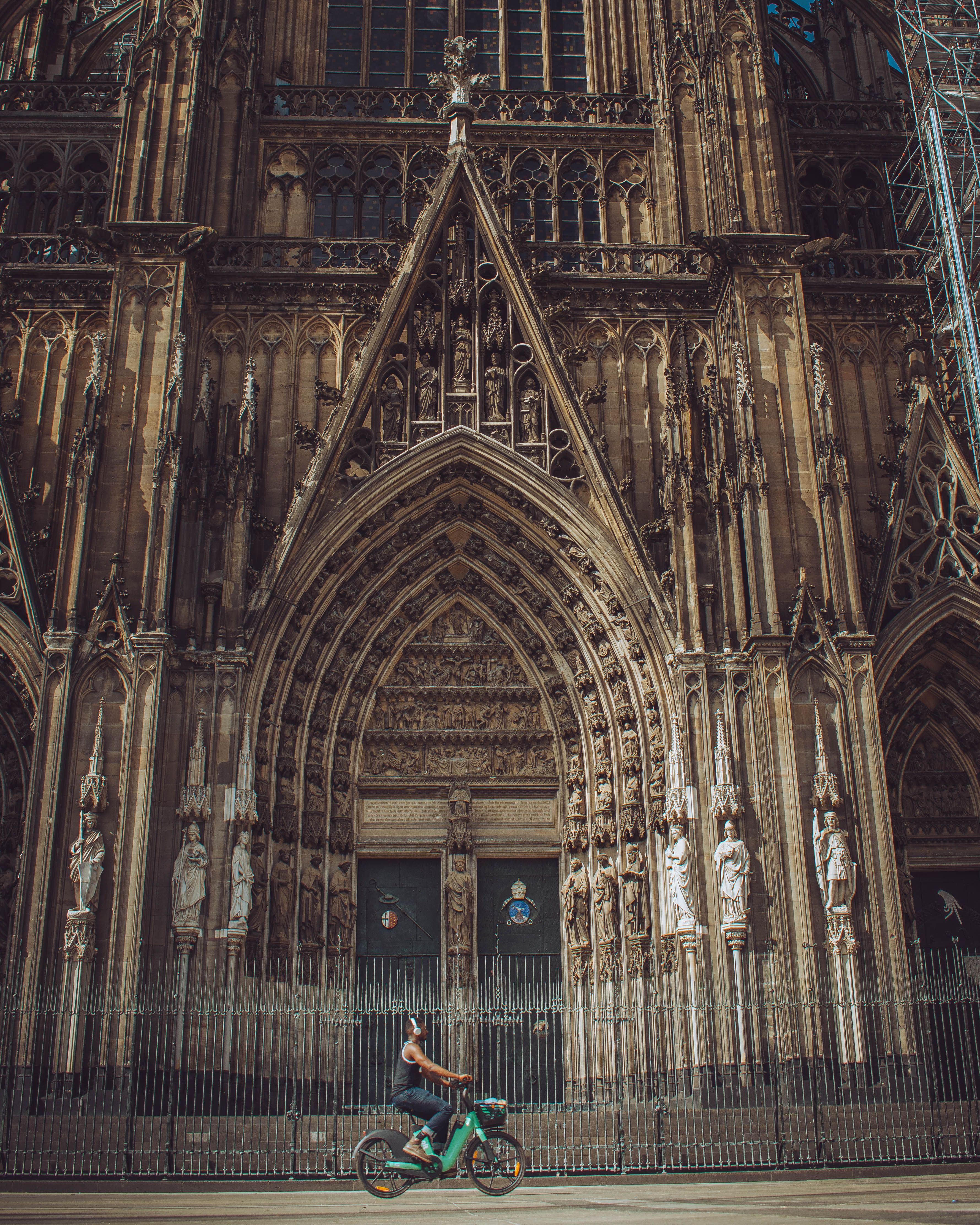 Man Sitting on Steps of the Cologne Cathedral · Free Stock Photo