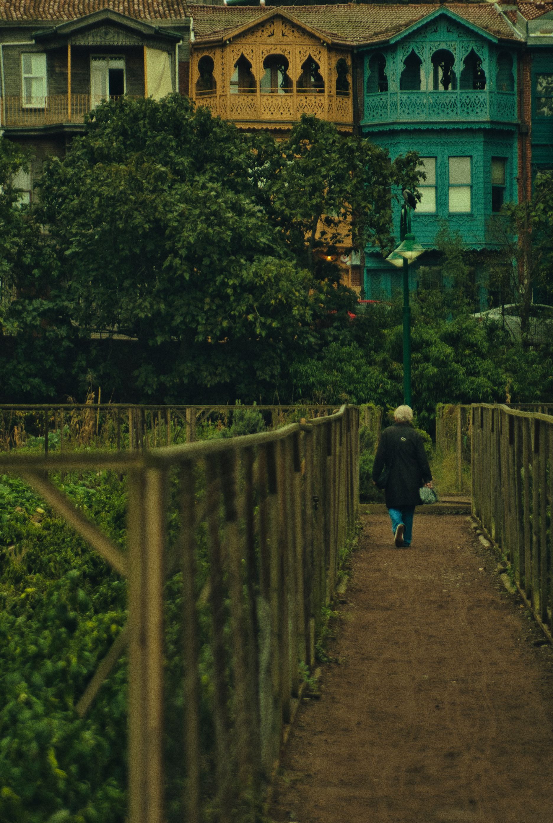 A person walking down a path in front of colorful houses · Free Stock Photo