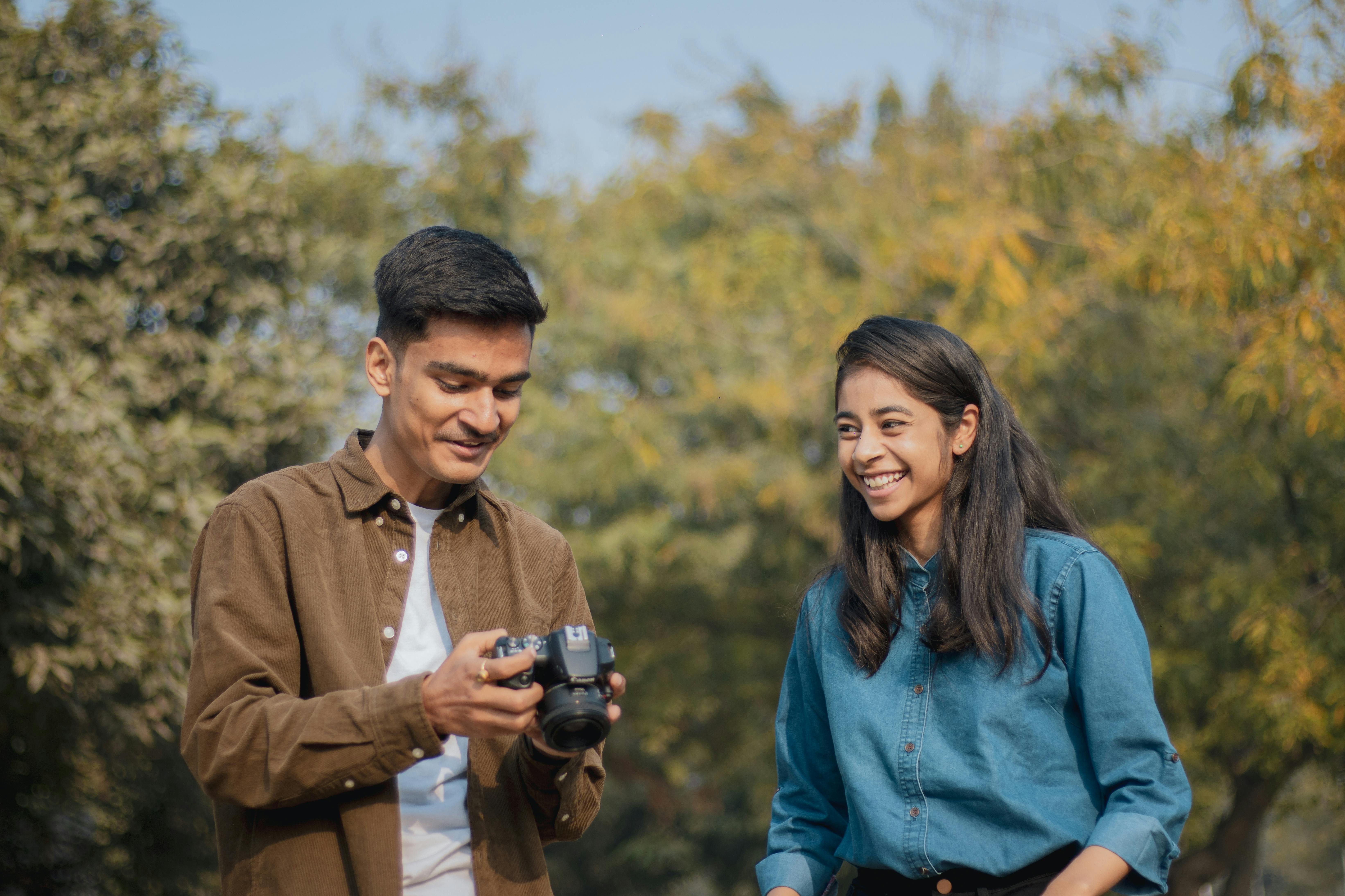 Young Indian photographer holding a professional dslr camera and ...