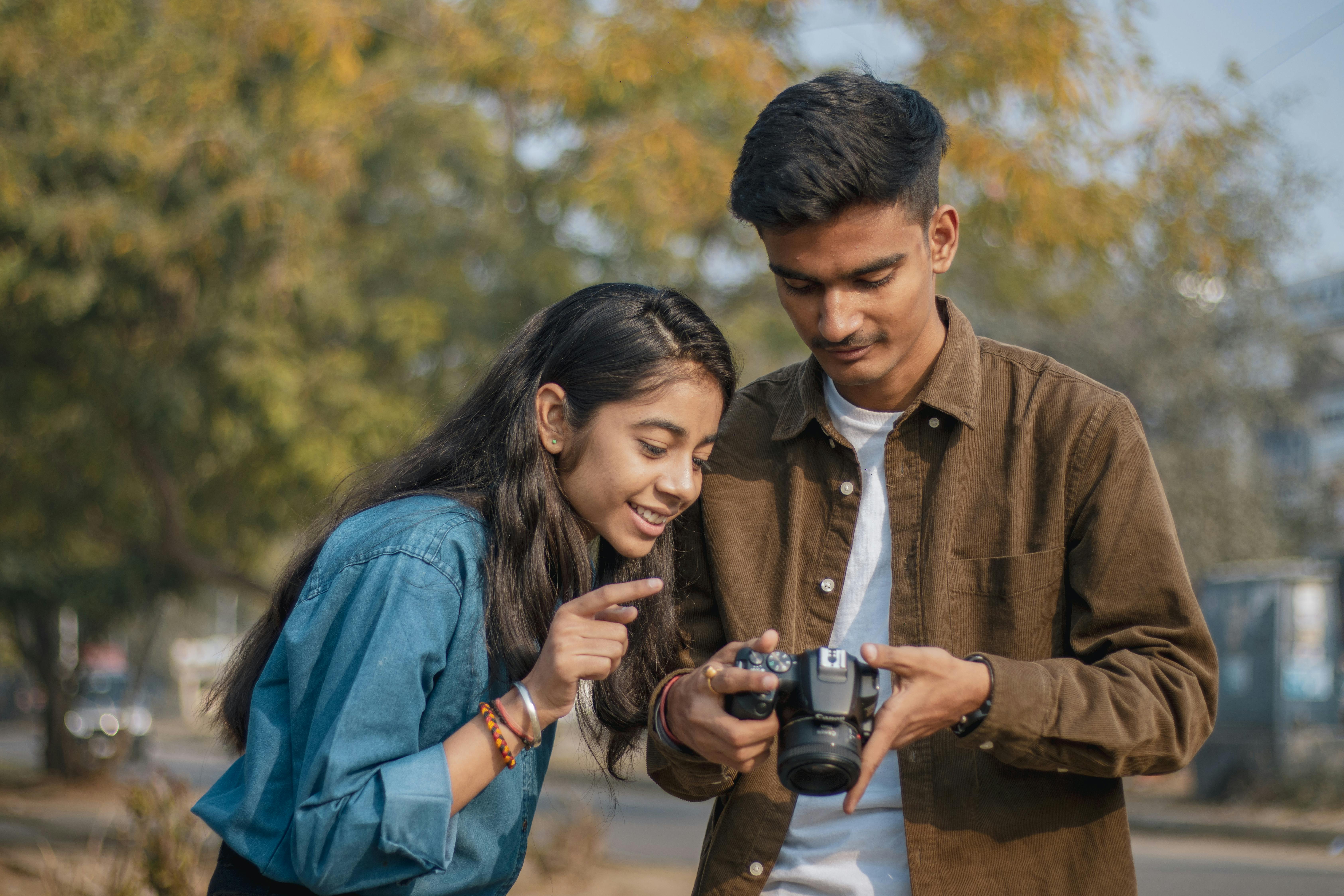 Young Indian photographer holding a professional dslr camera and ...