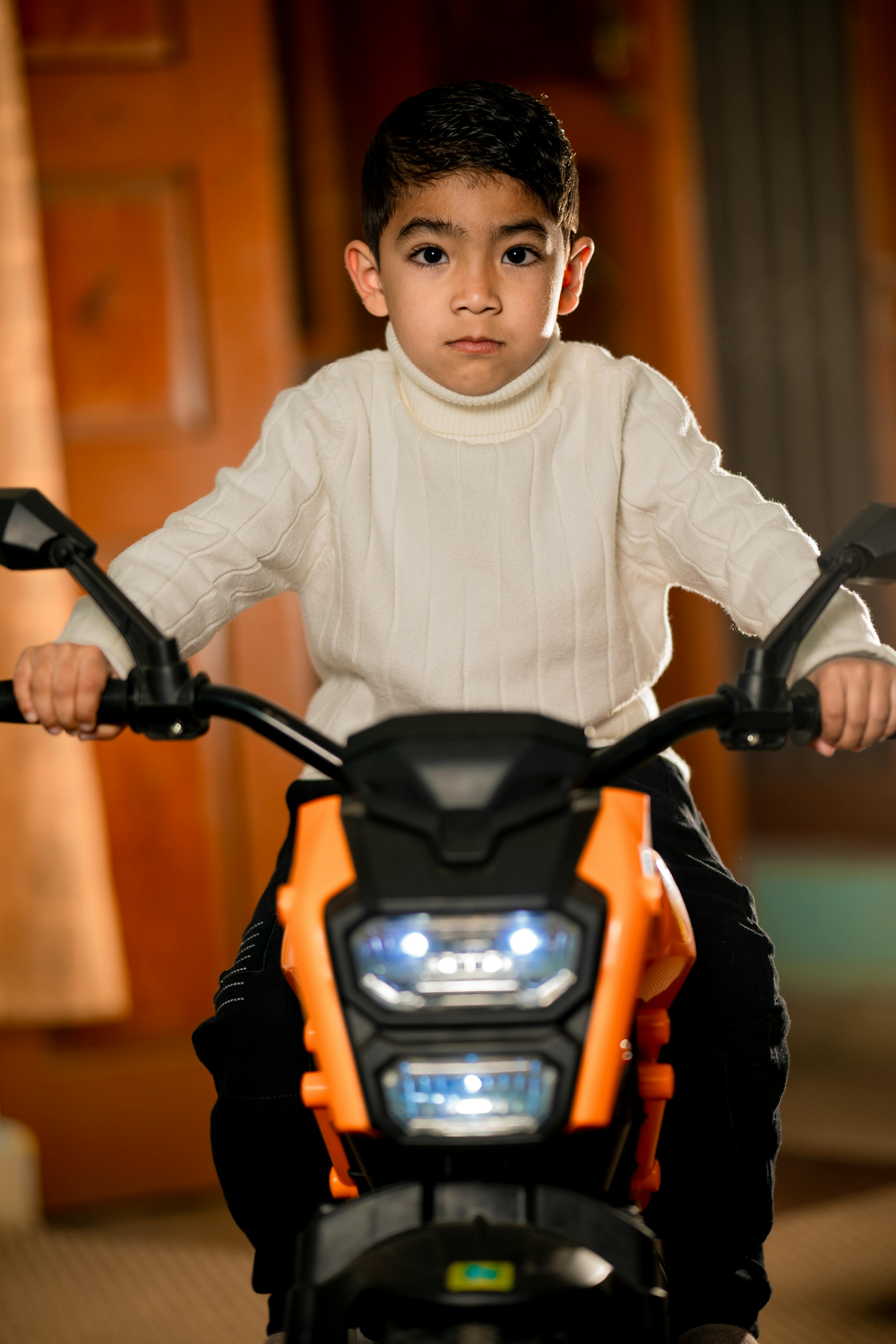 A Boy Sitting on His Mini Motorcycle · Free Stock Photo