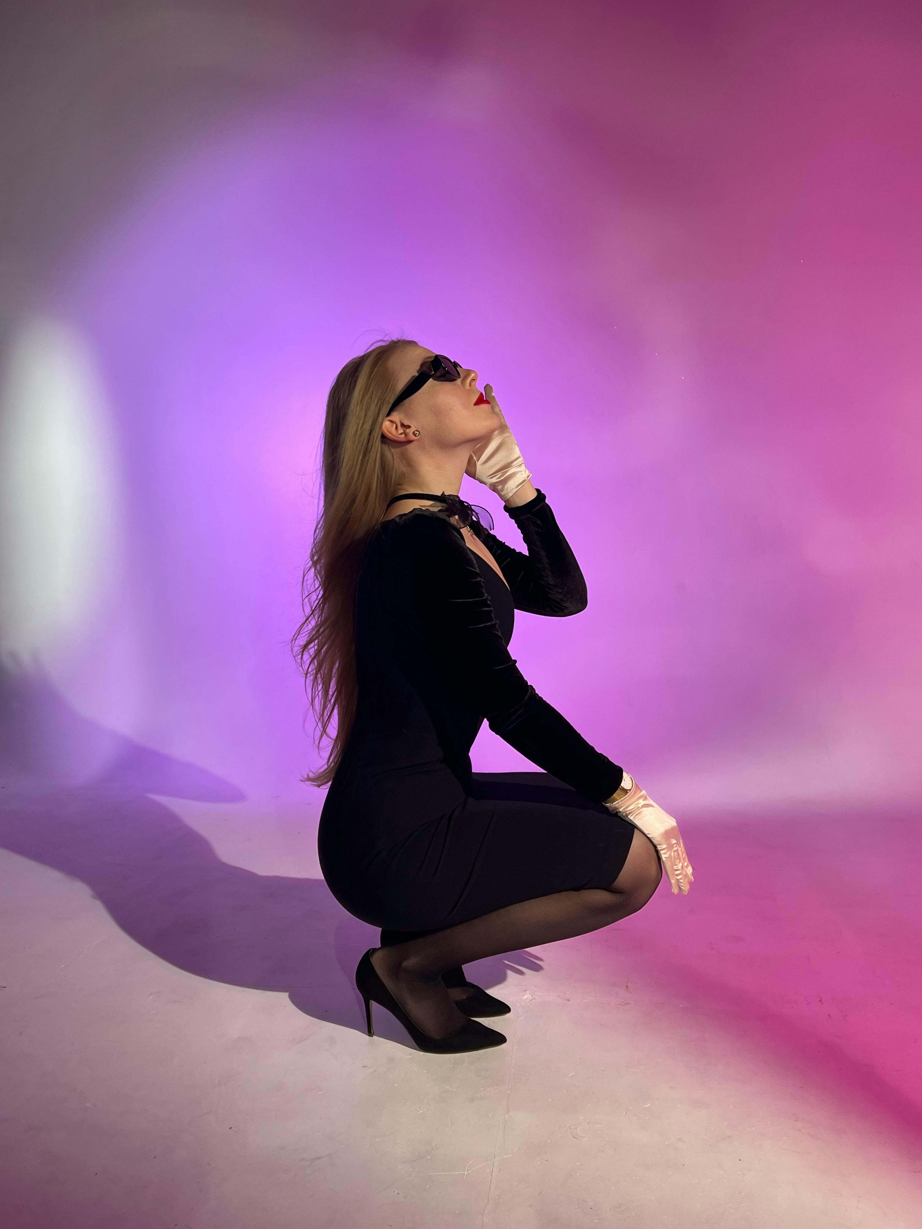 Female Model Crouching in Black Jacket and Black Heels · Free Stock Photo