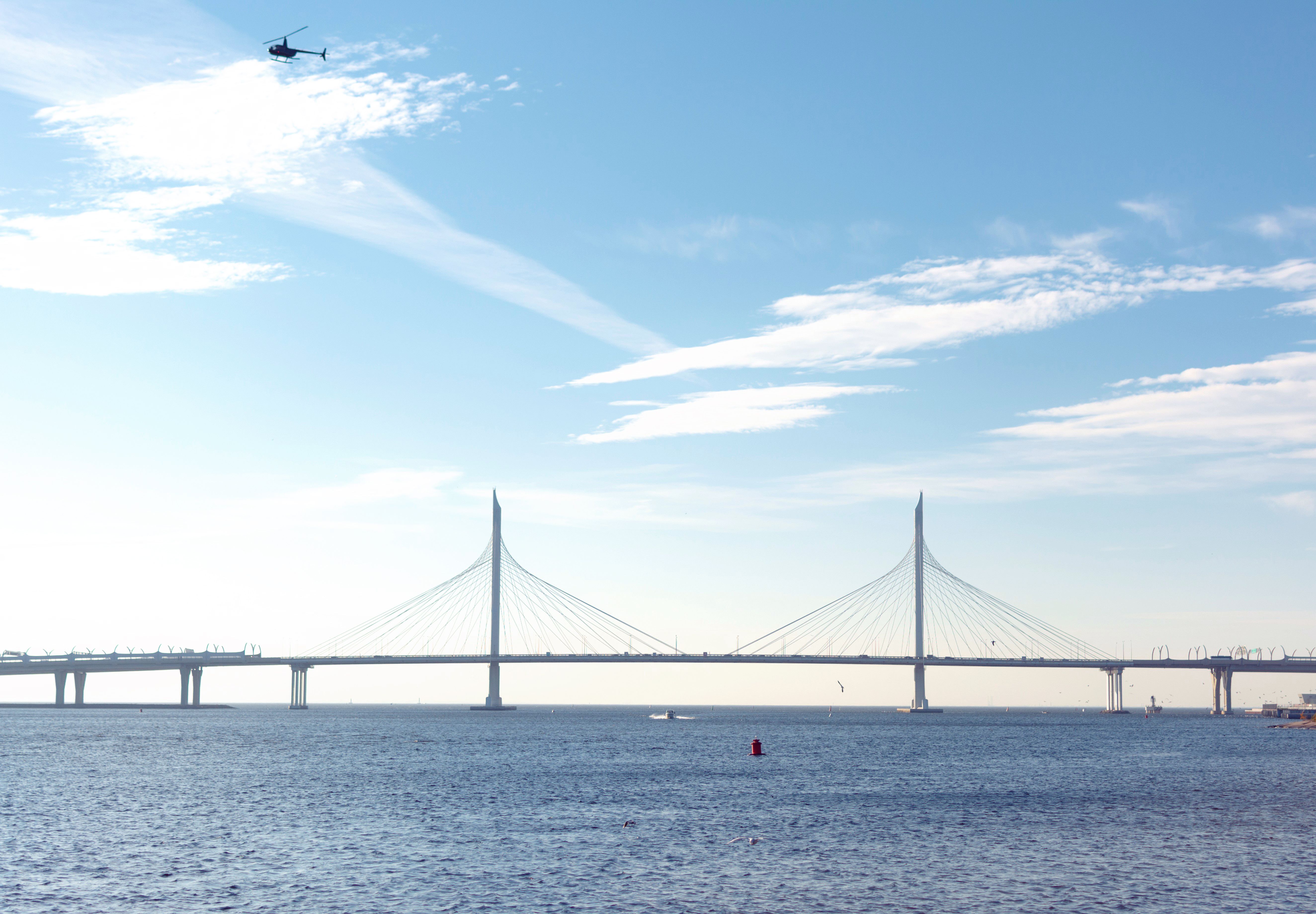 Helicopter Flying above Suspension Bridge · Free Stock Photo