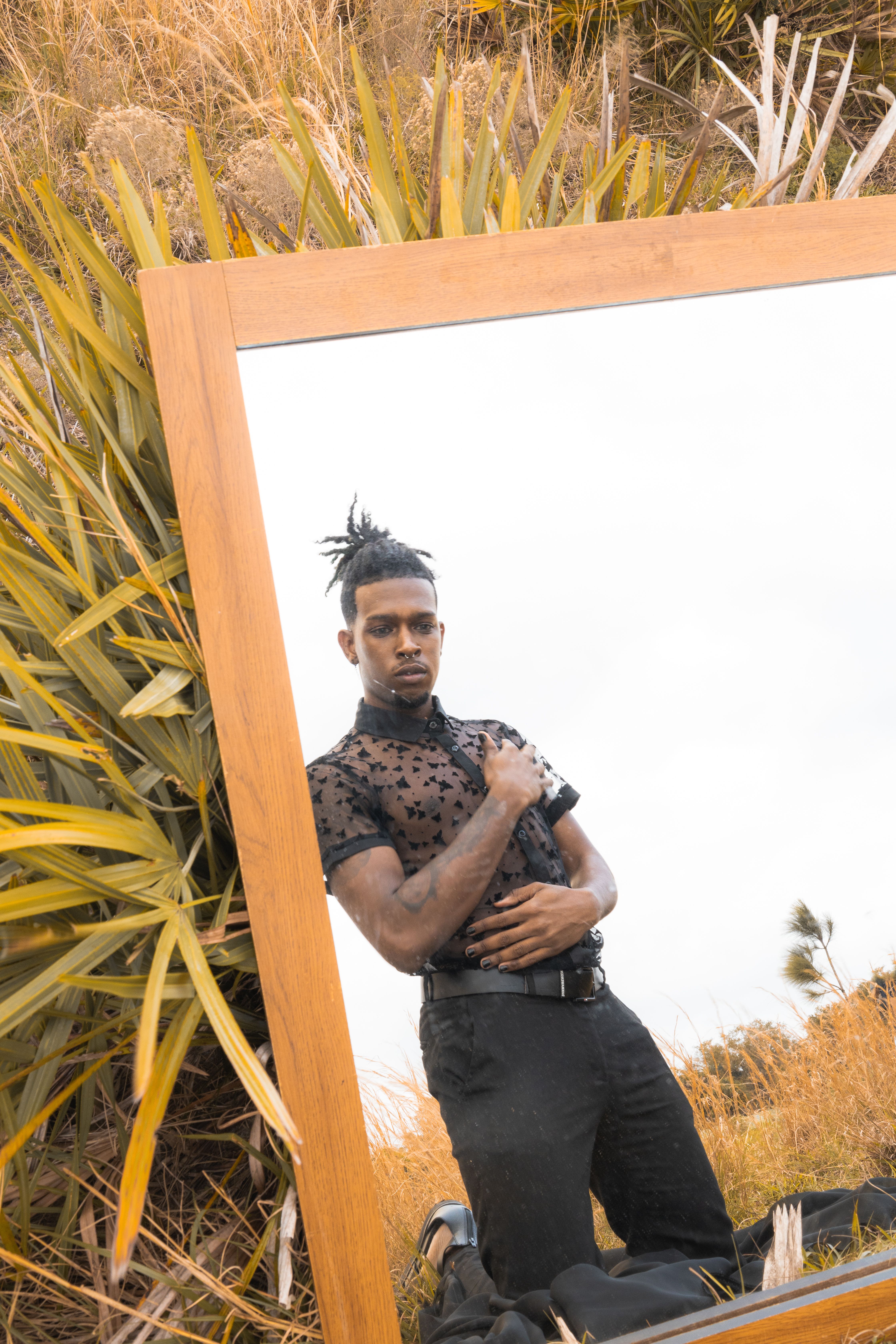 A man standing in front of a mirror with a black shirt · Free Stock Photo