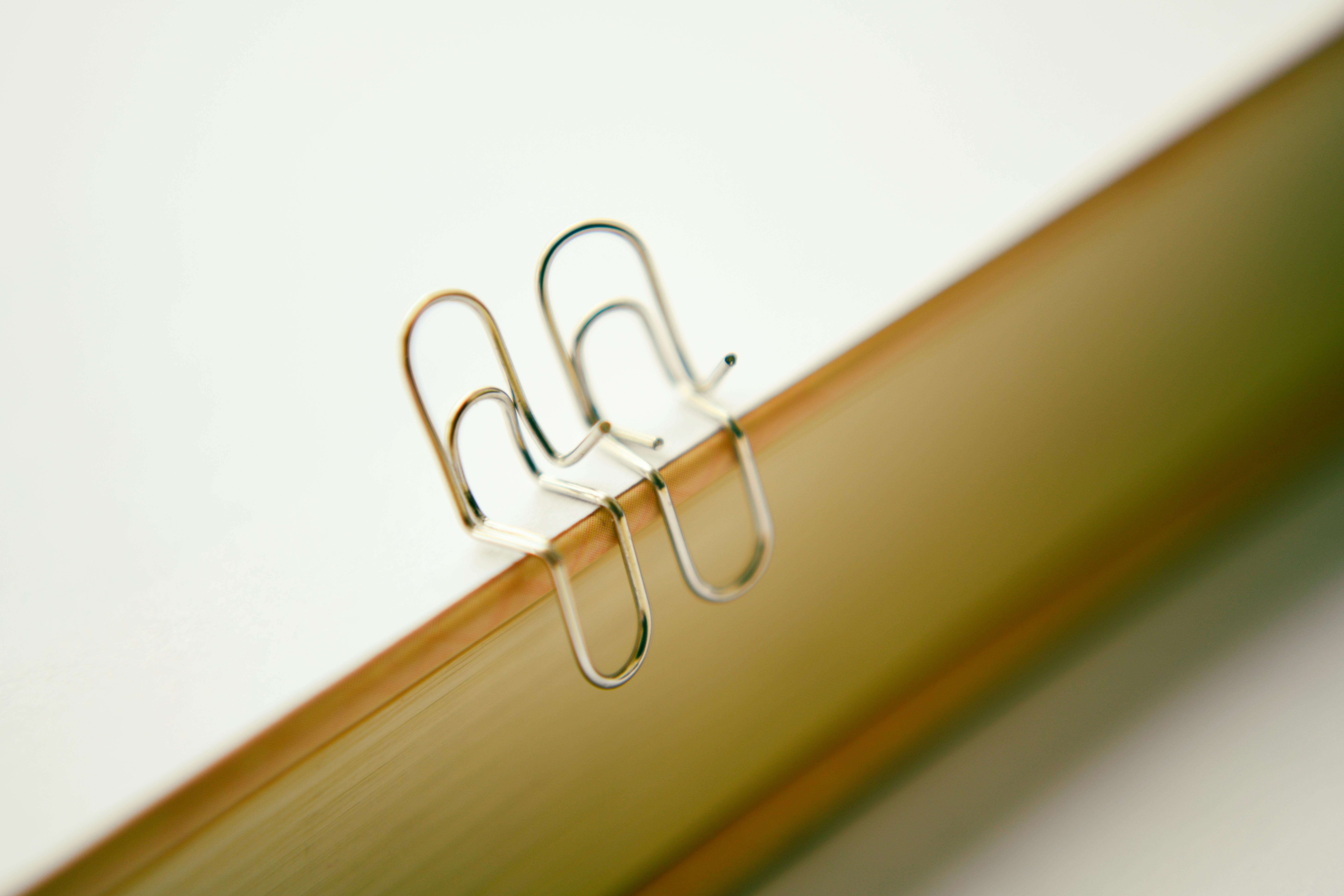 Bent Paperclips Lying on Book Cover · Free Stock Photo