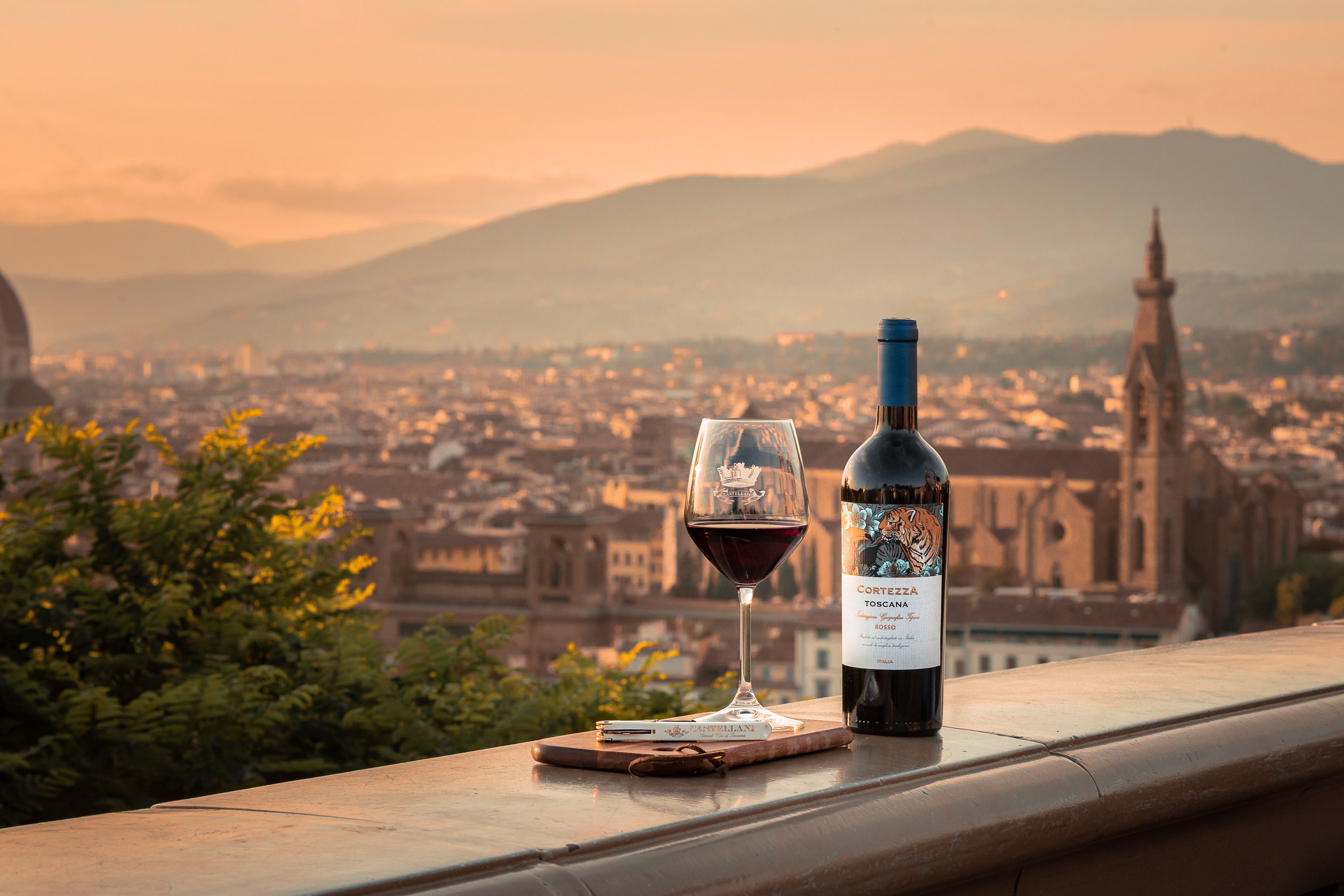 A Bottle and a Glass of Red Wine on a Terrace with the View of a City ...