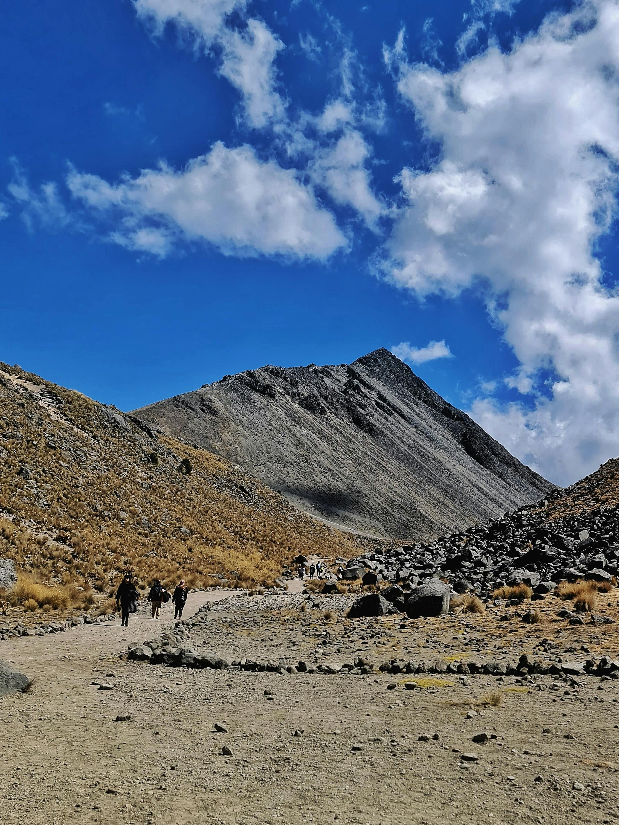People on Path Between Mountains · Free Stock Photo