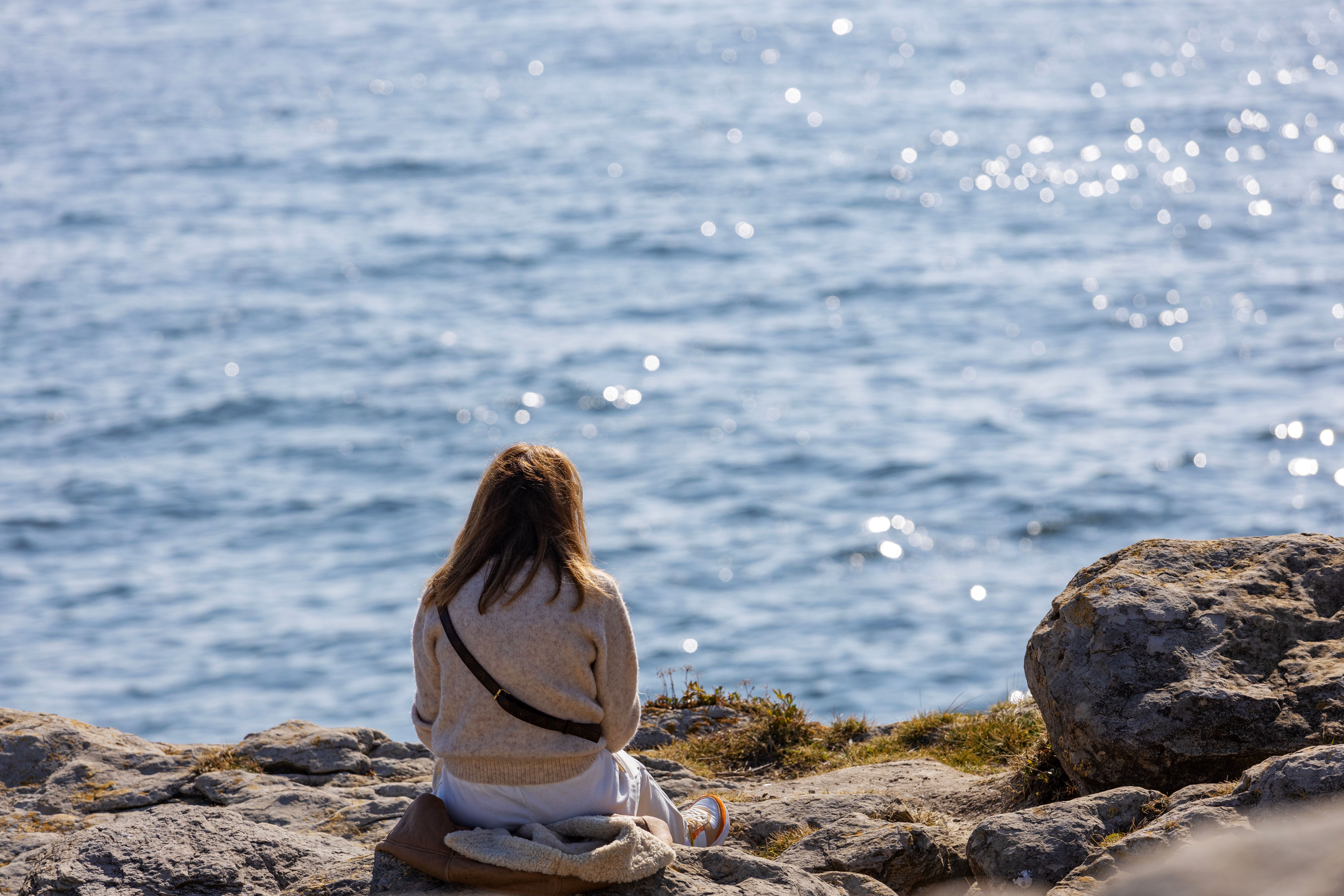 Photo of a Girl Sitting by the Sea · Free Stock Photo
