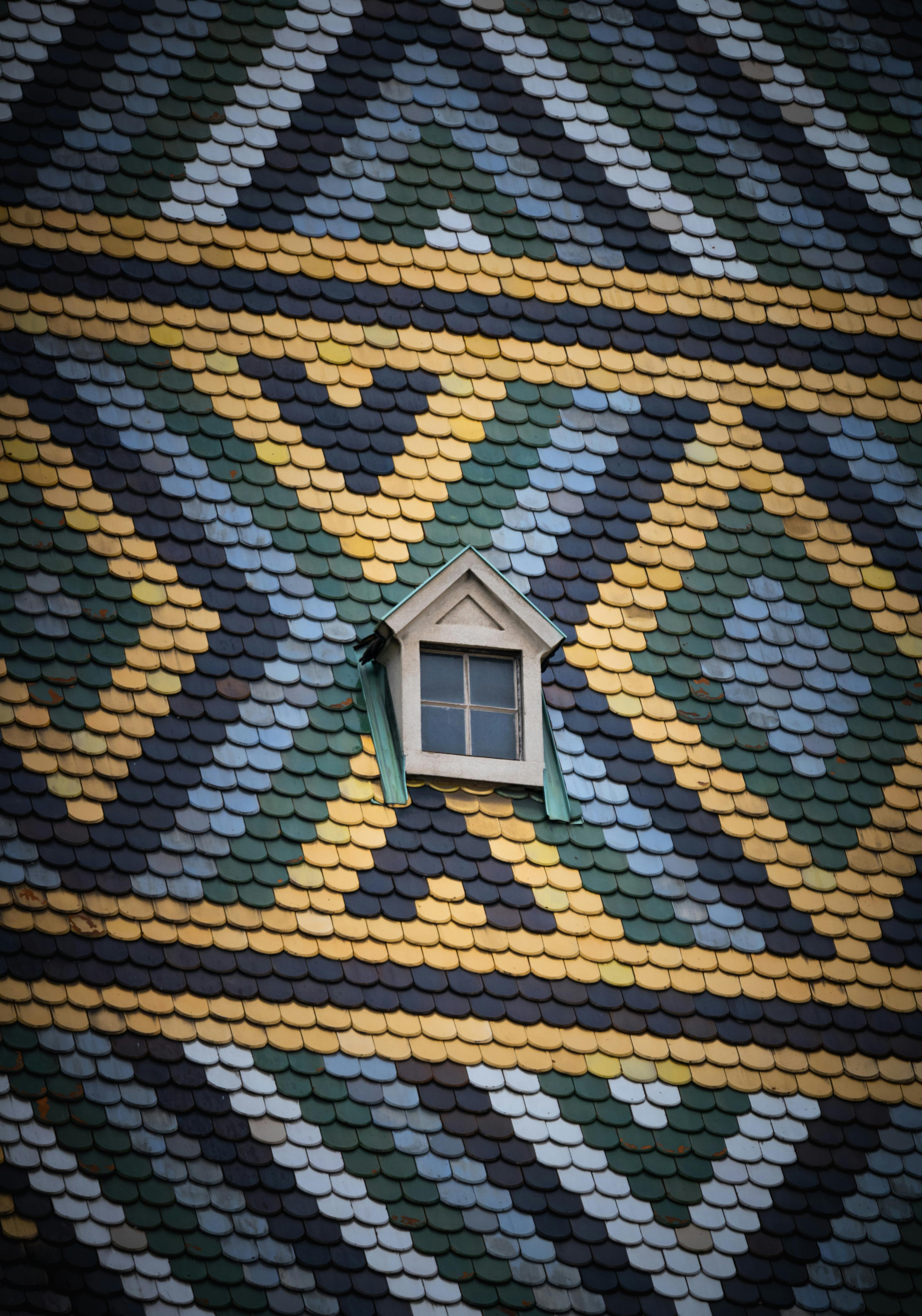 A window in a colorful tile roof · Free Stock Photo