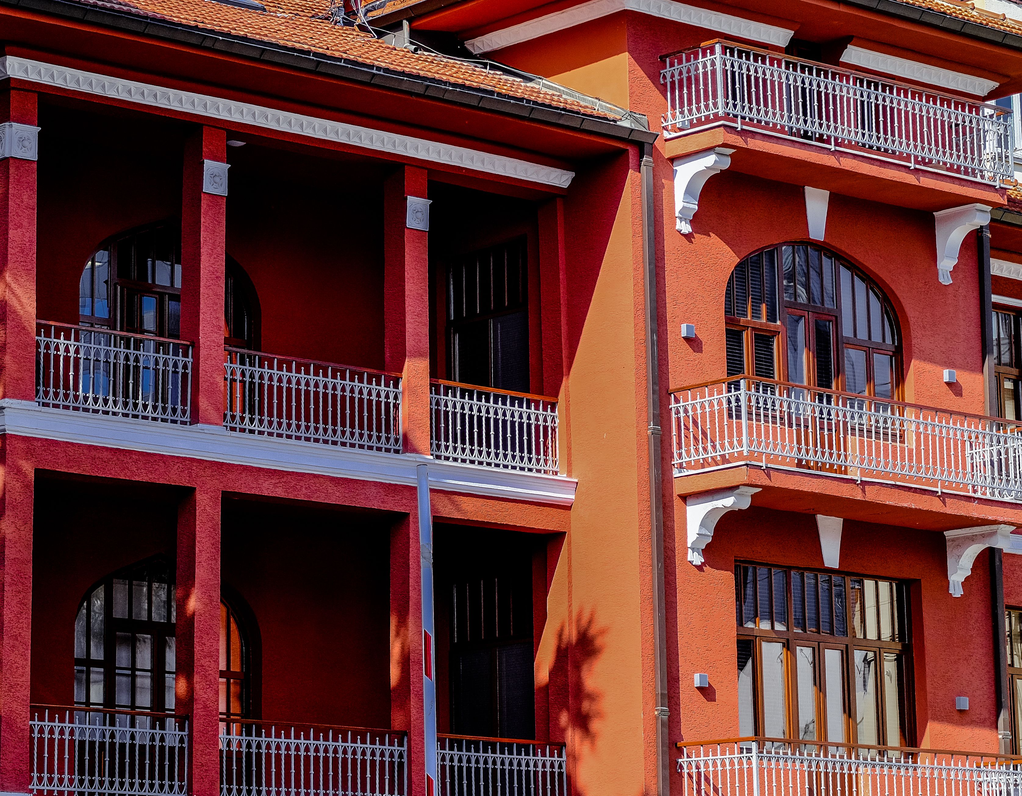 Facade of a Red Building with Balconies and Windows with Wooden Frames ...