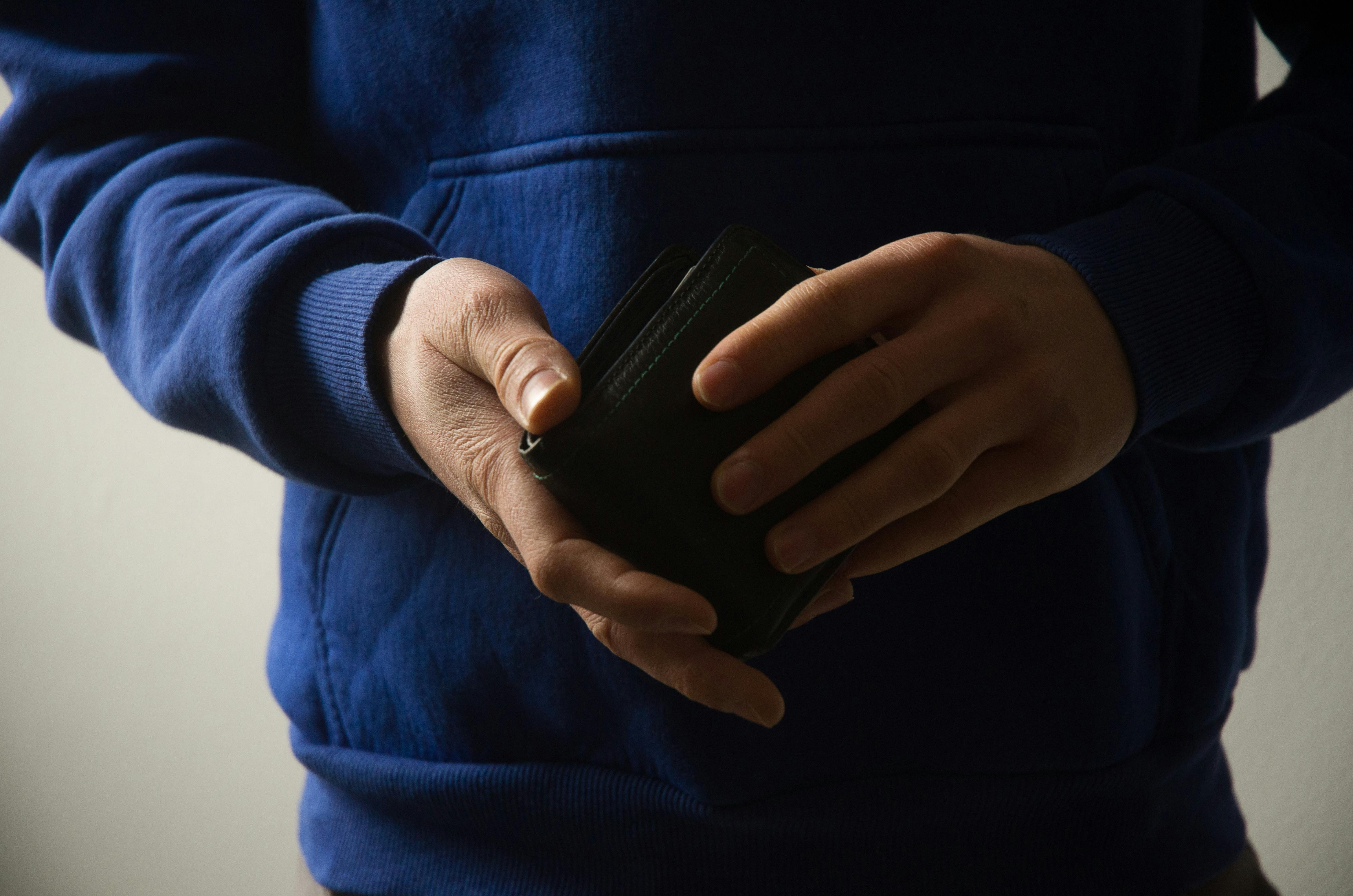 Close-up of Man Holding Wallet in Hands · Free Stock Photo