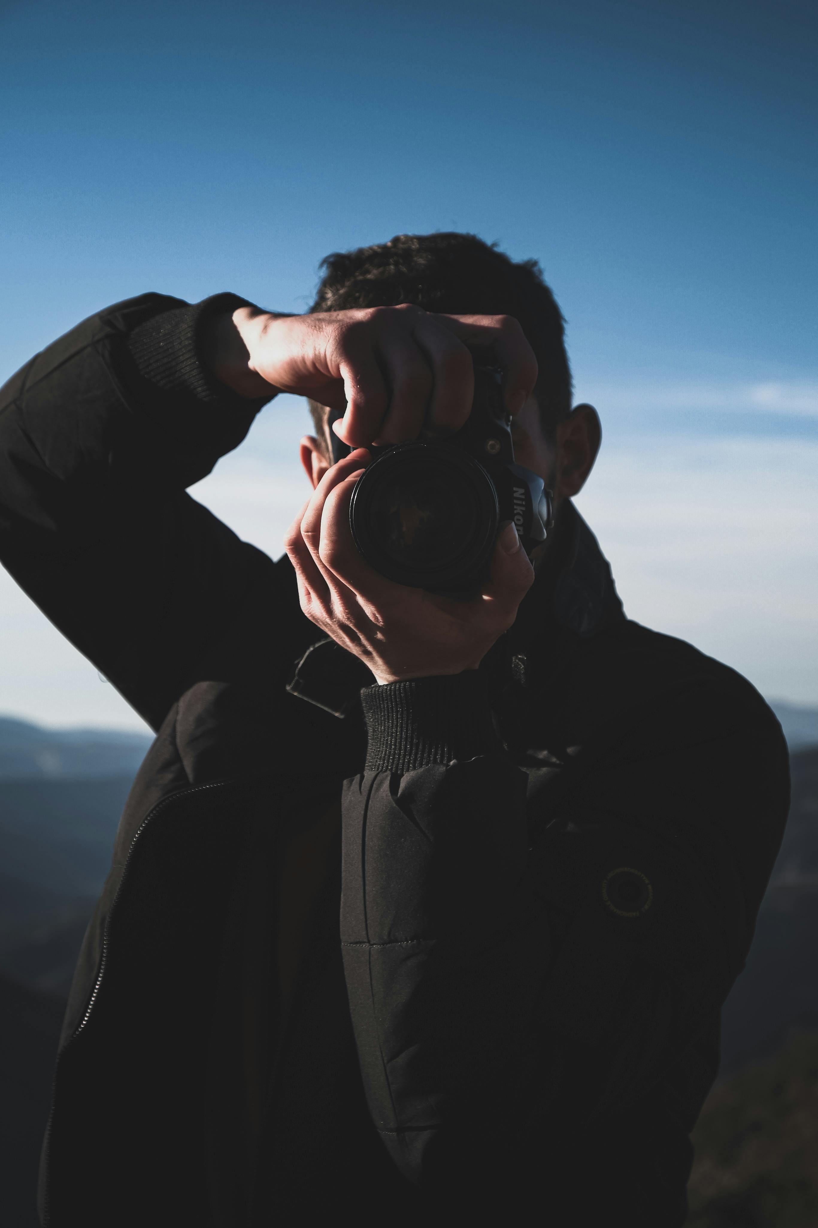 Portrait of Man Holding up Camera Lenses to his Face · Free Stock Photo