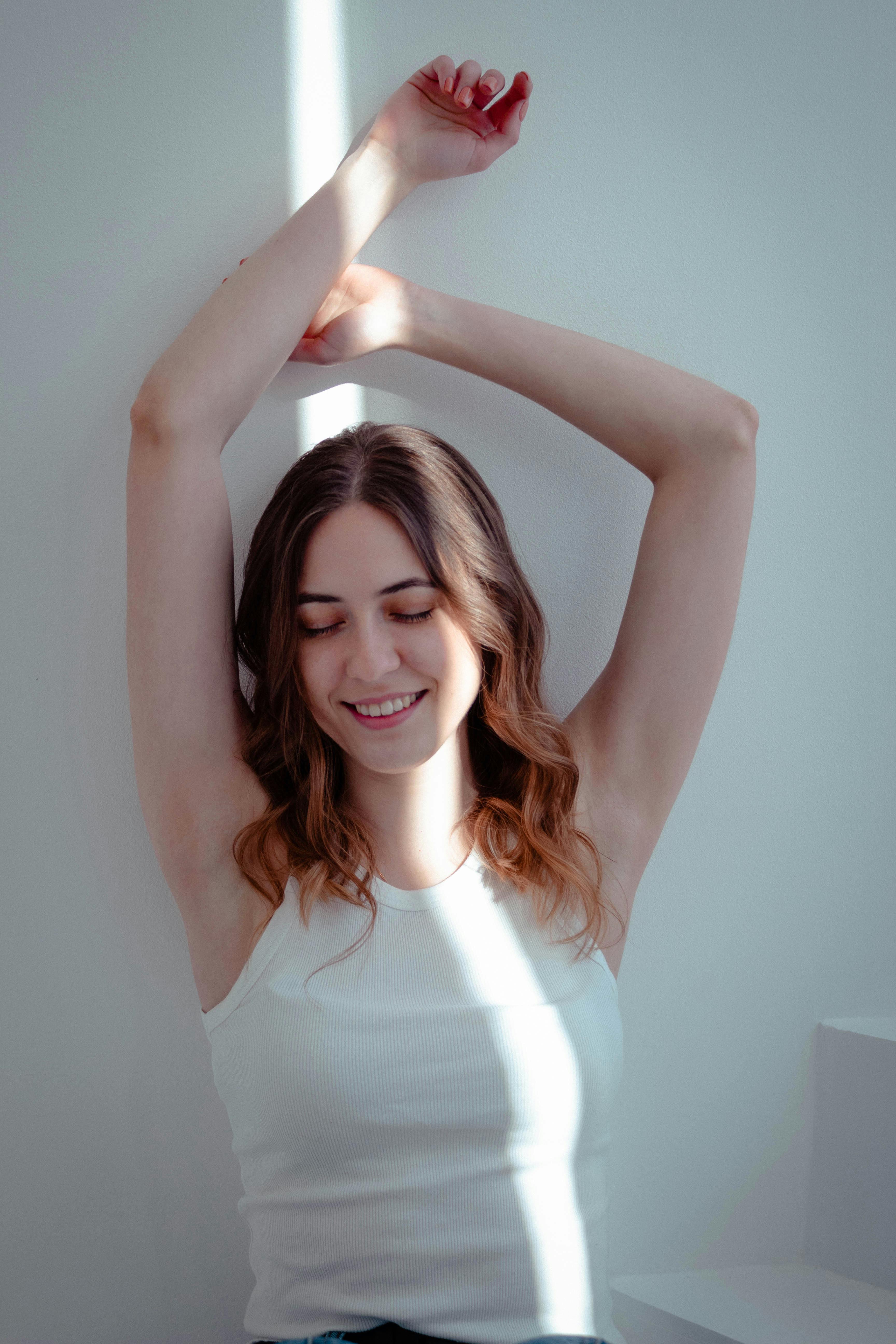 Smiling Woman near Wall with Light on Body · Free Stock Photo
