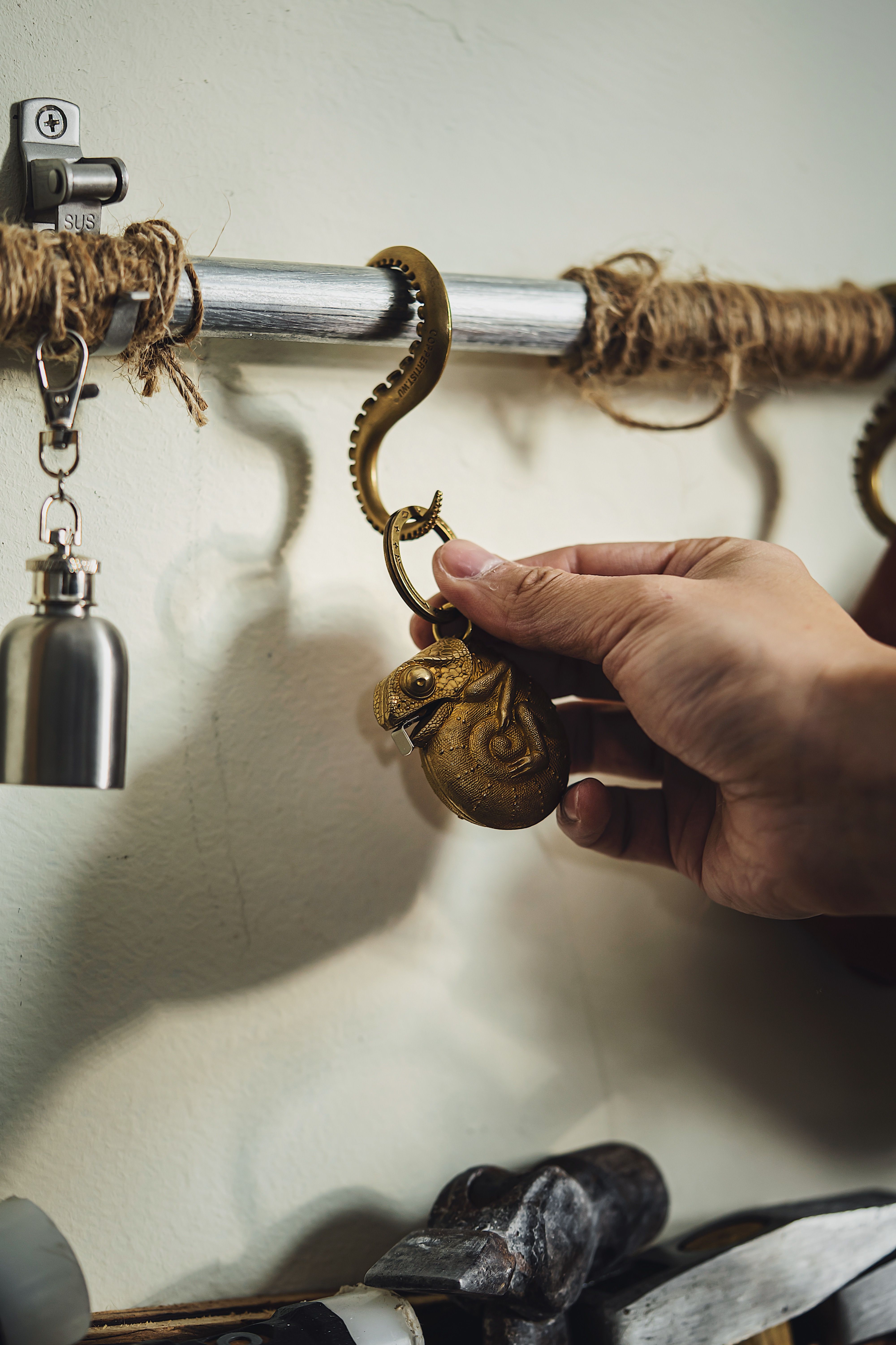 Hand Hanging a Key Chain on an Octopus Tentacle Hook · Free Stock Photo