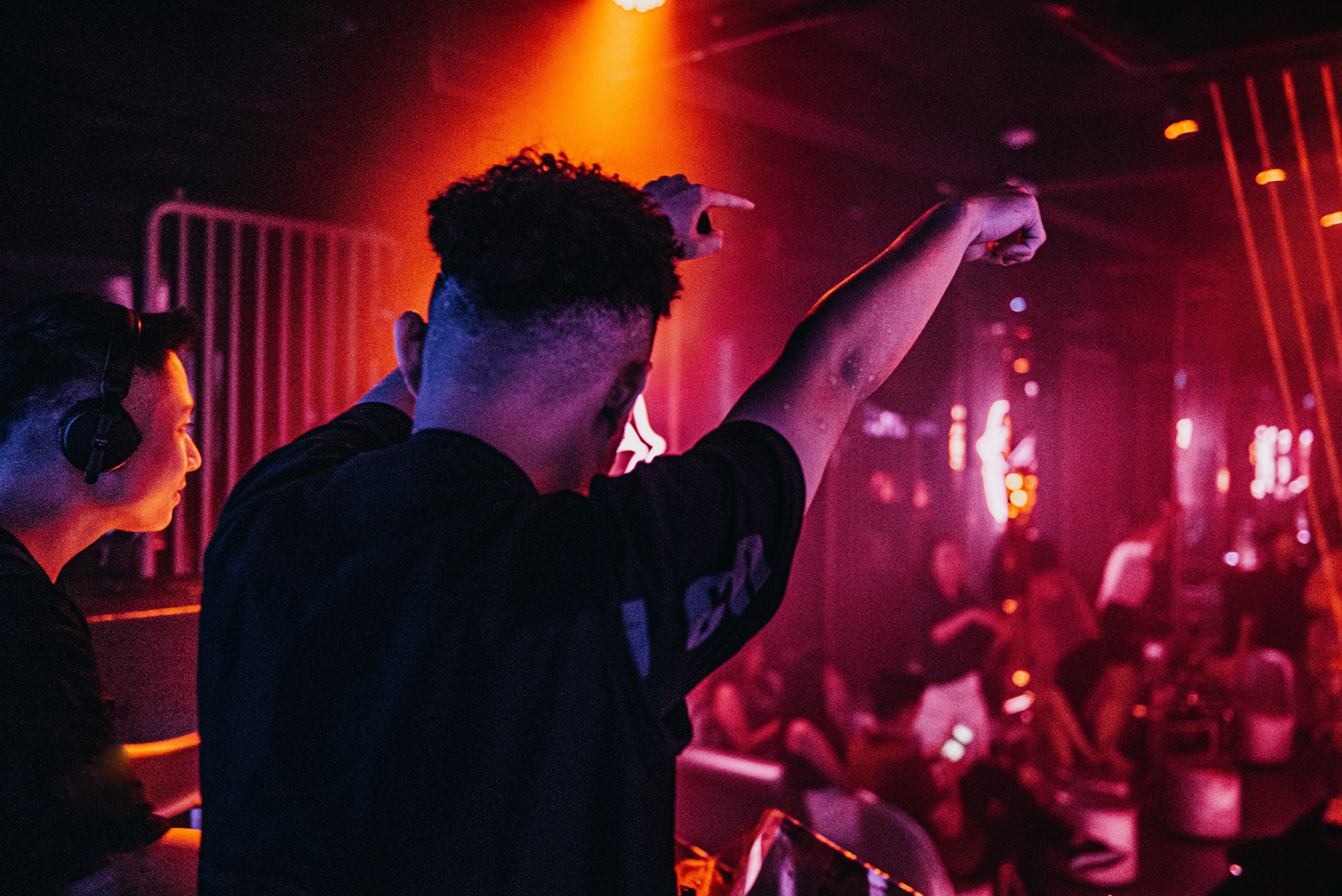 DJ Raising Arms in a Nightclub · Free Stock Photo