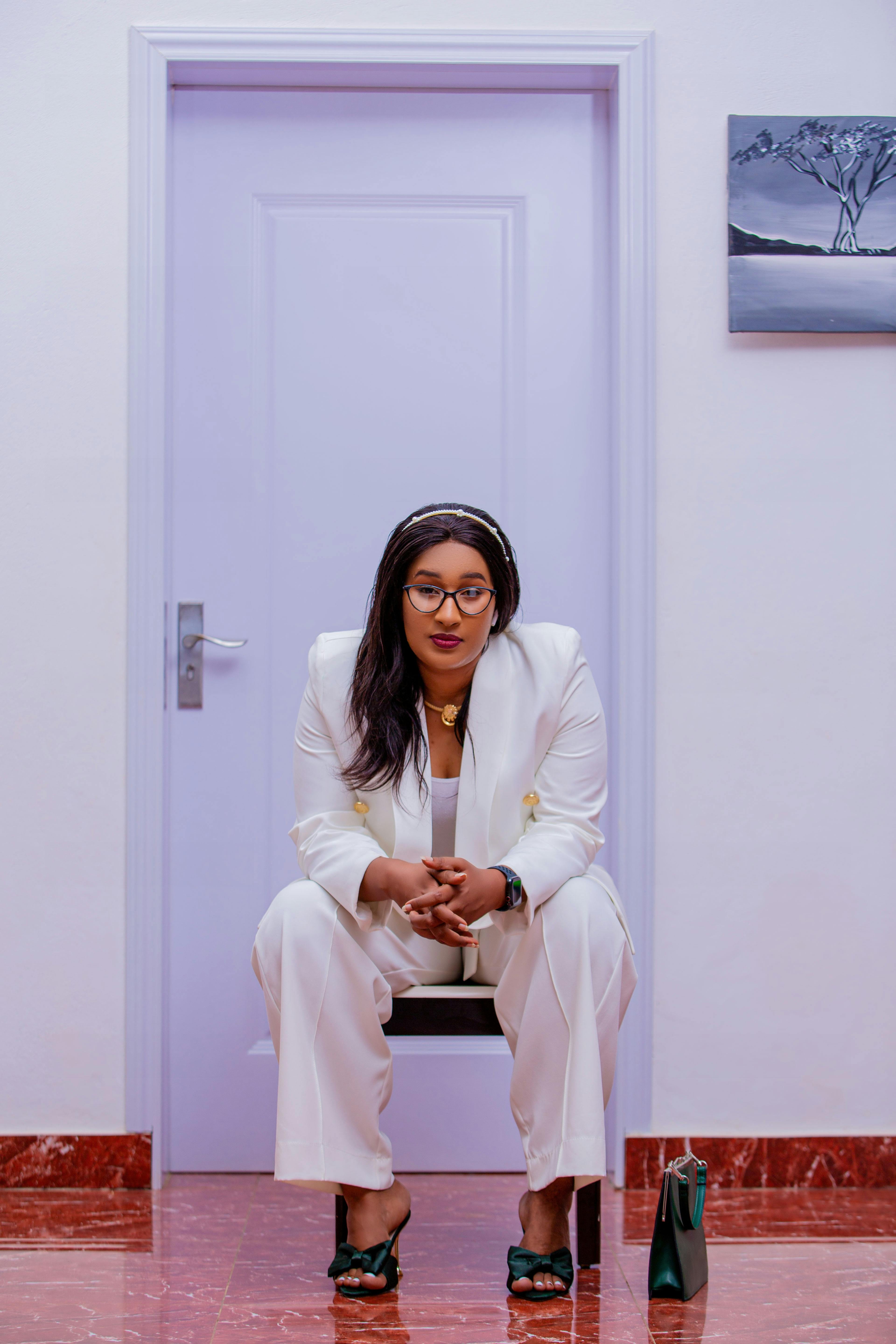 Woman in a Suit Sitting in front of the Door · Free Stock Photo