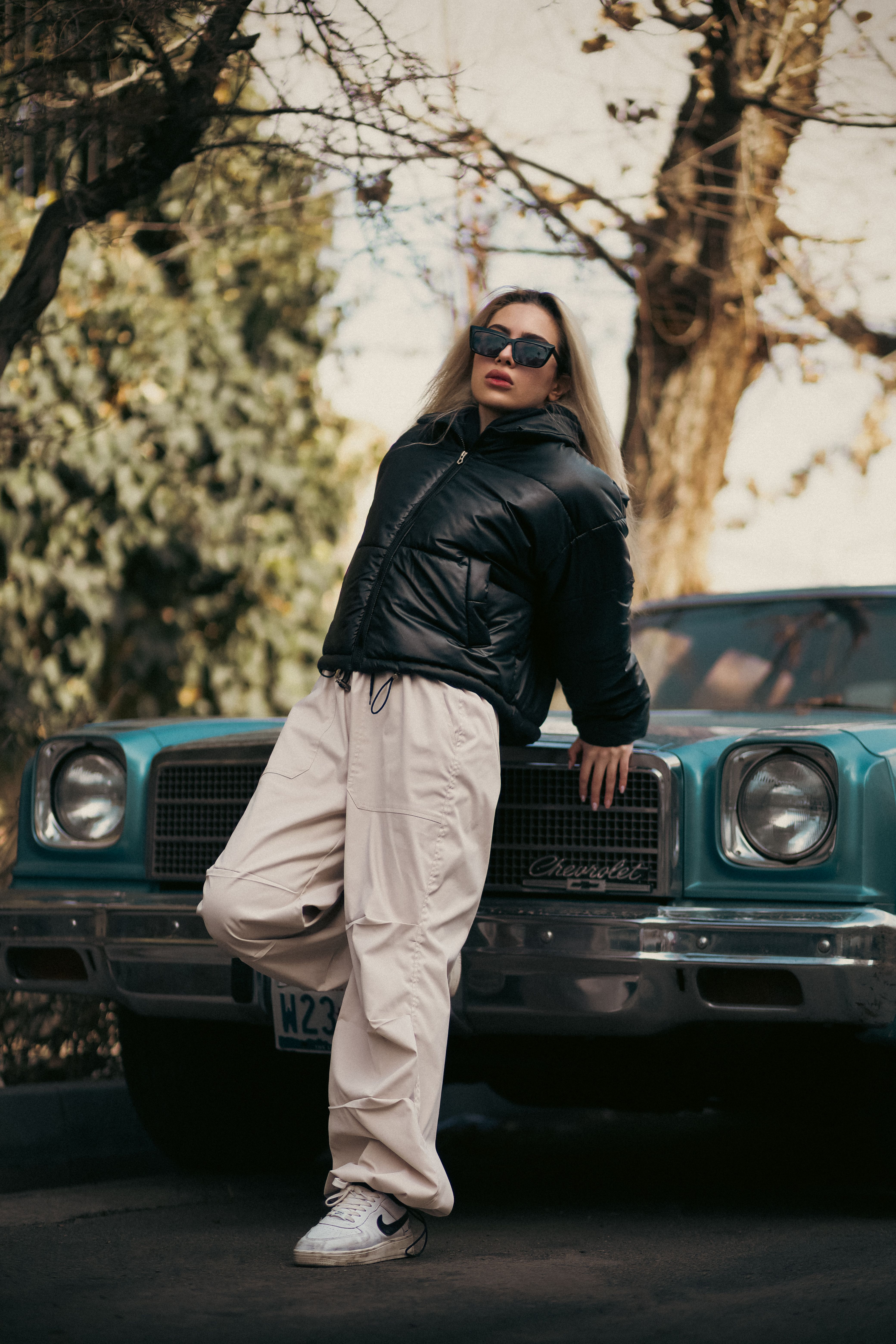 Woman in Puffer Jacket Posing by Classic Car · Free Stock Photo