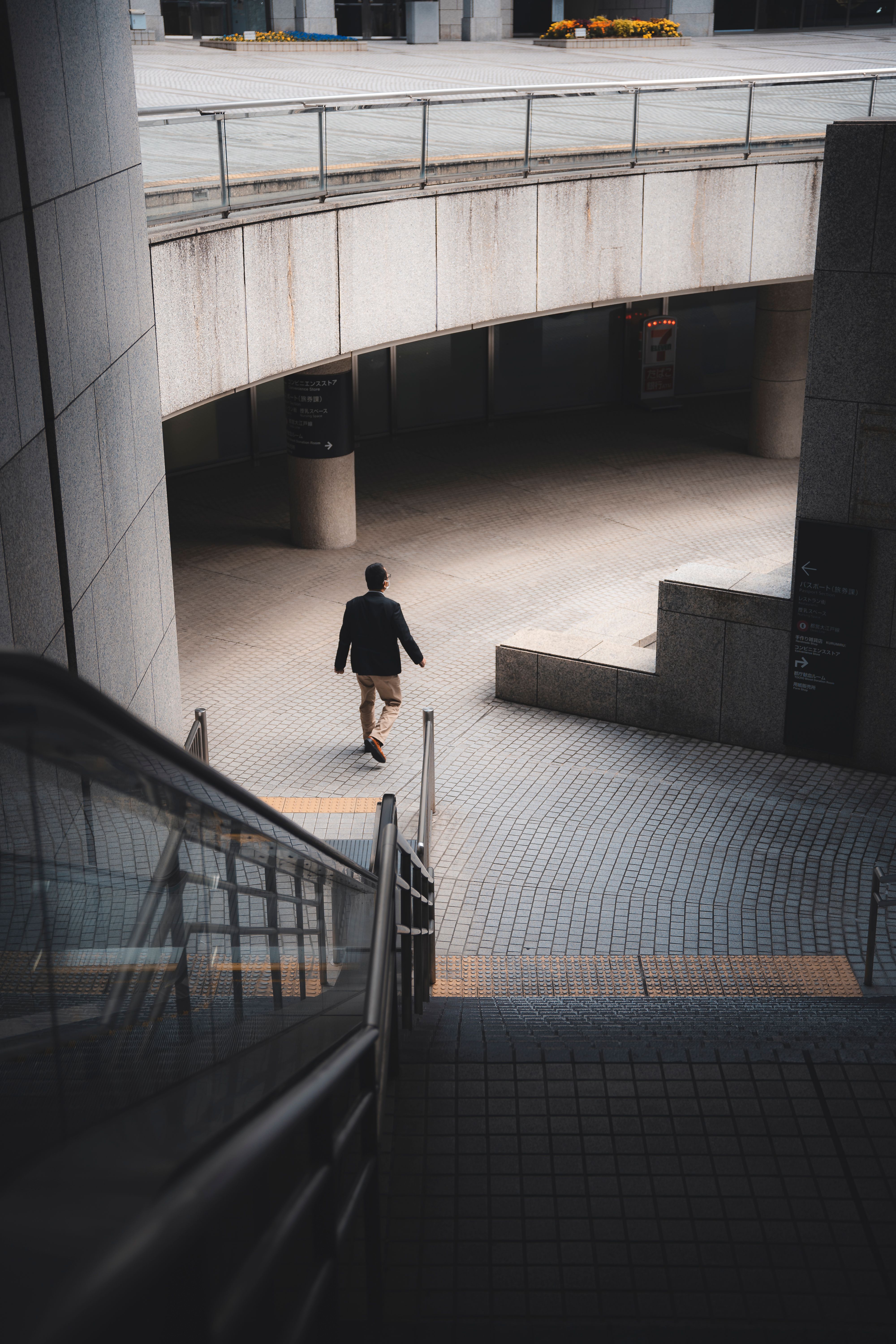 Man Walking near Stairs of Stone City Building · Free Stock Photo