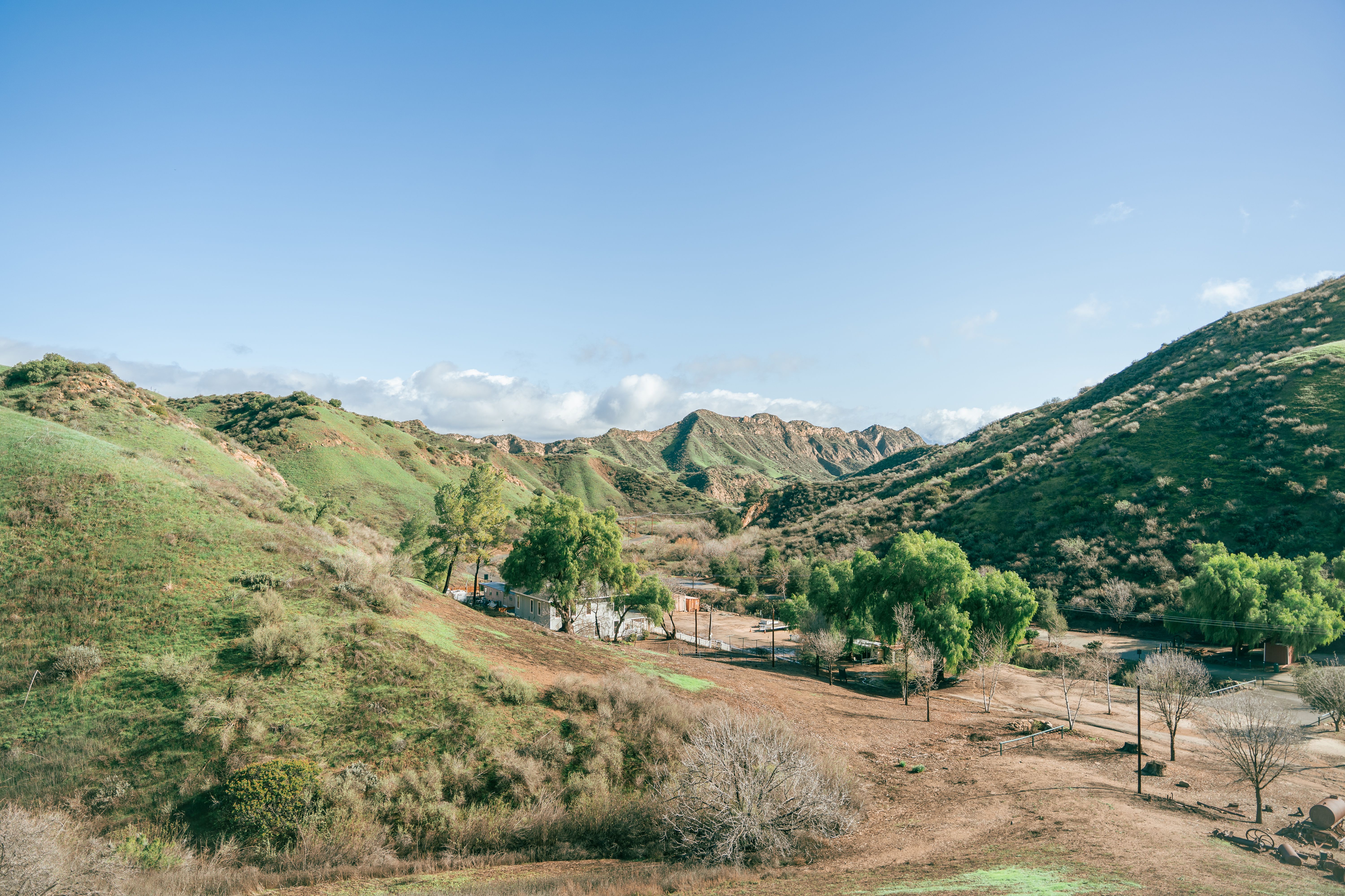 Farm in a Valley Between Green Hills · Free Stock Photo