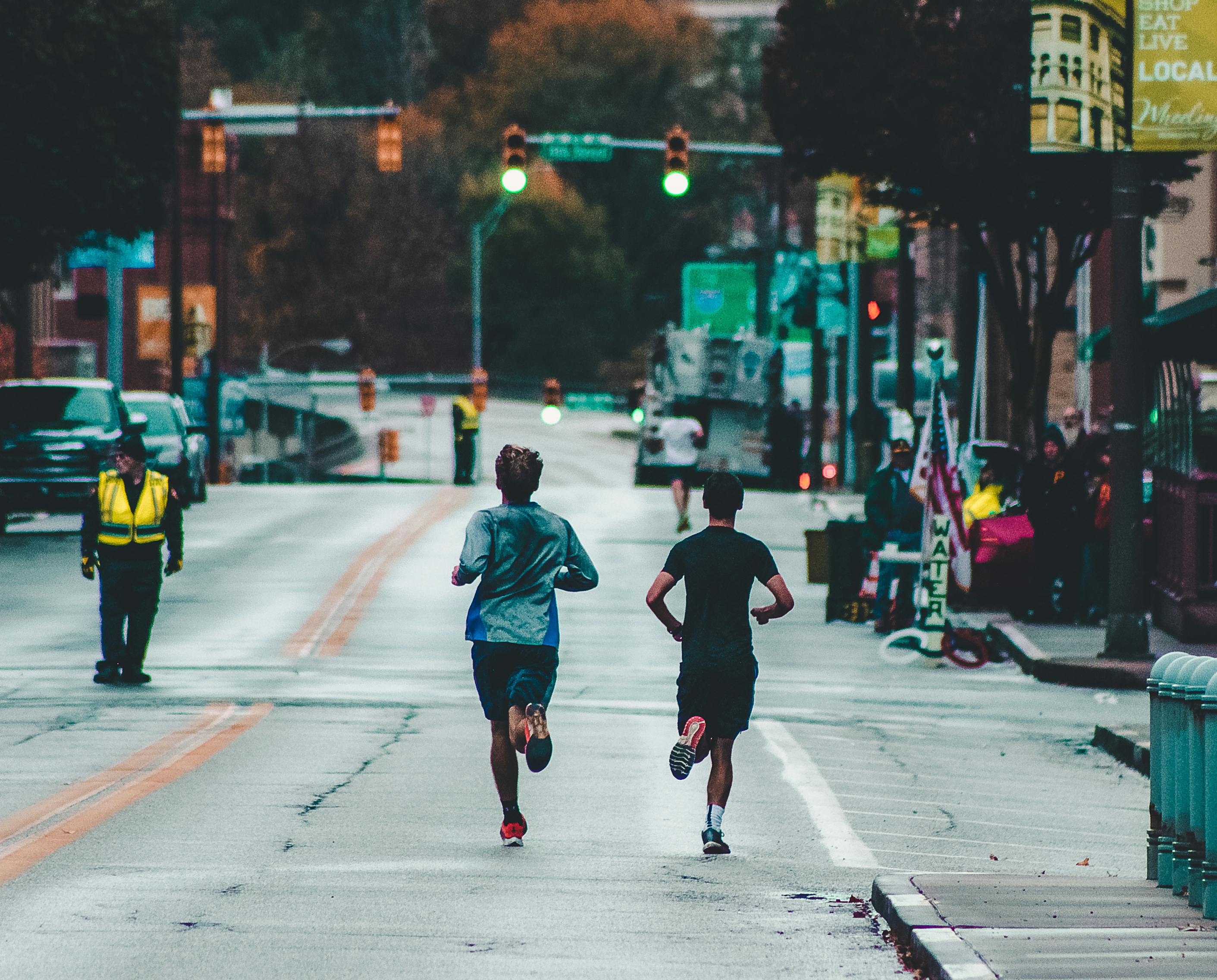 Two Men Running On Concrete Road · Free Stock Photo