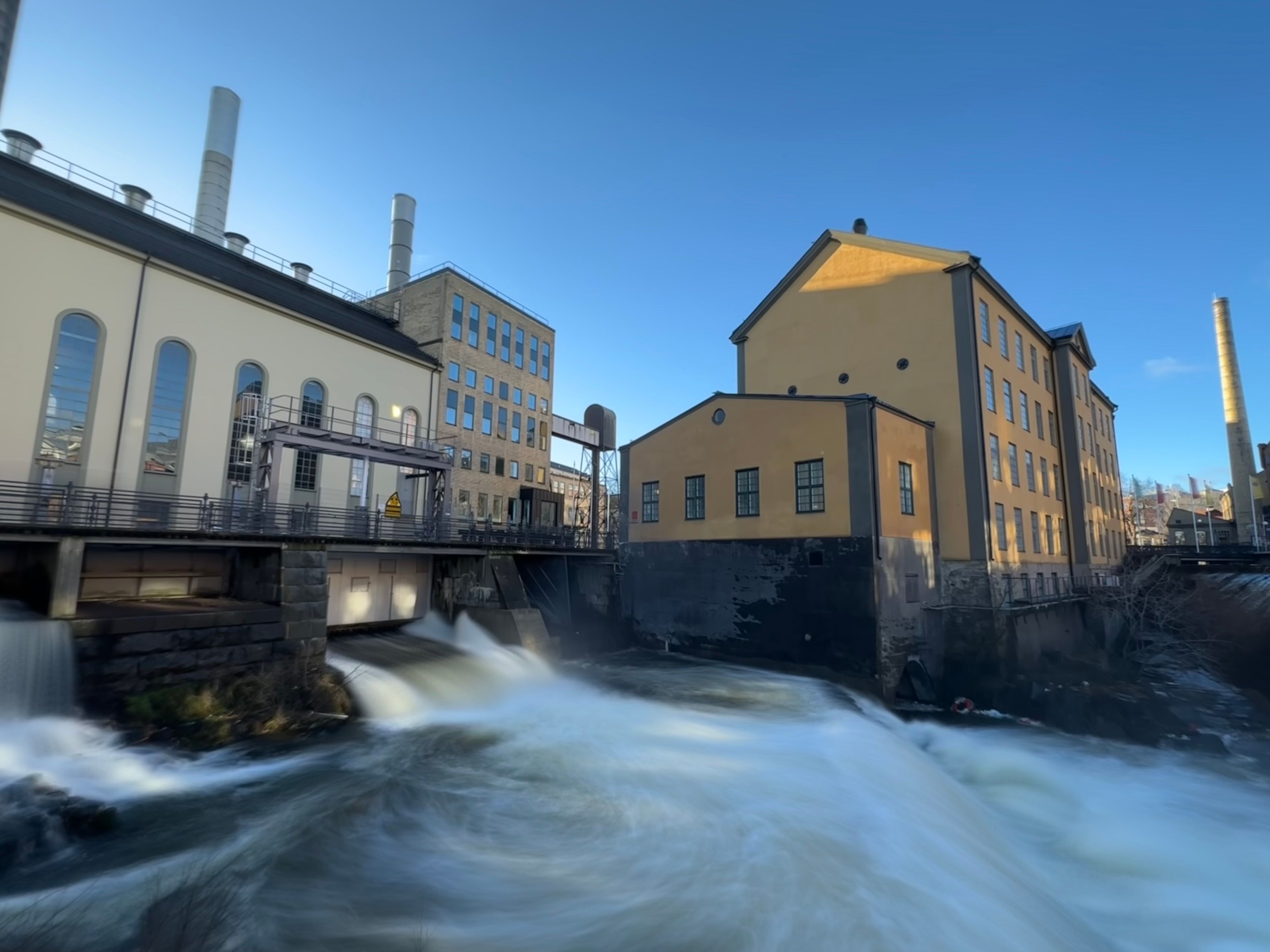 Water Flowing on Dam under Buildings · Free Stock Photo