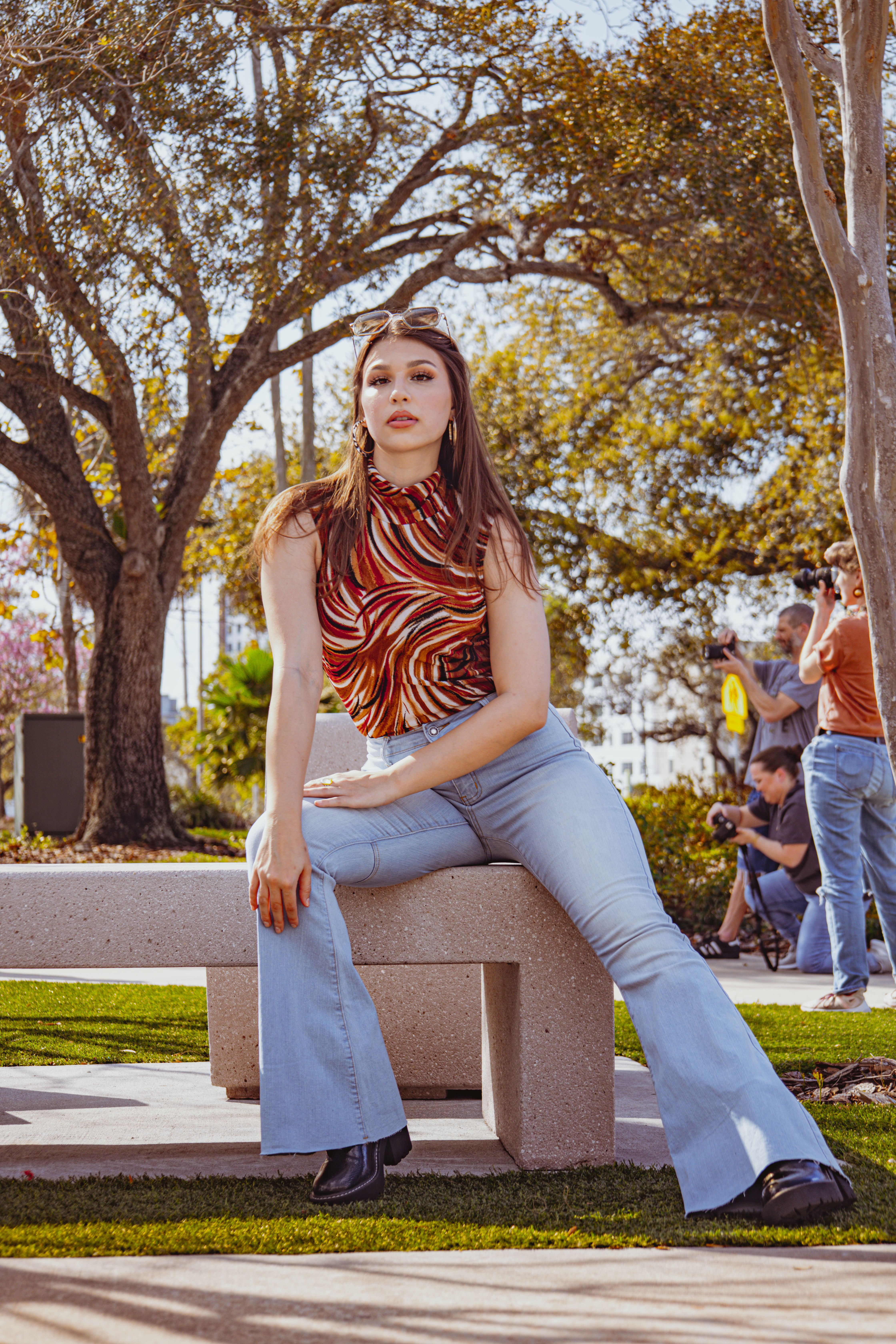 A woman in jeans and a top sitting on a bench · Free Stock Photo