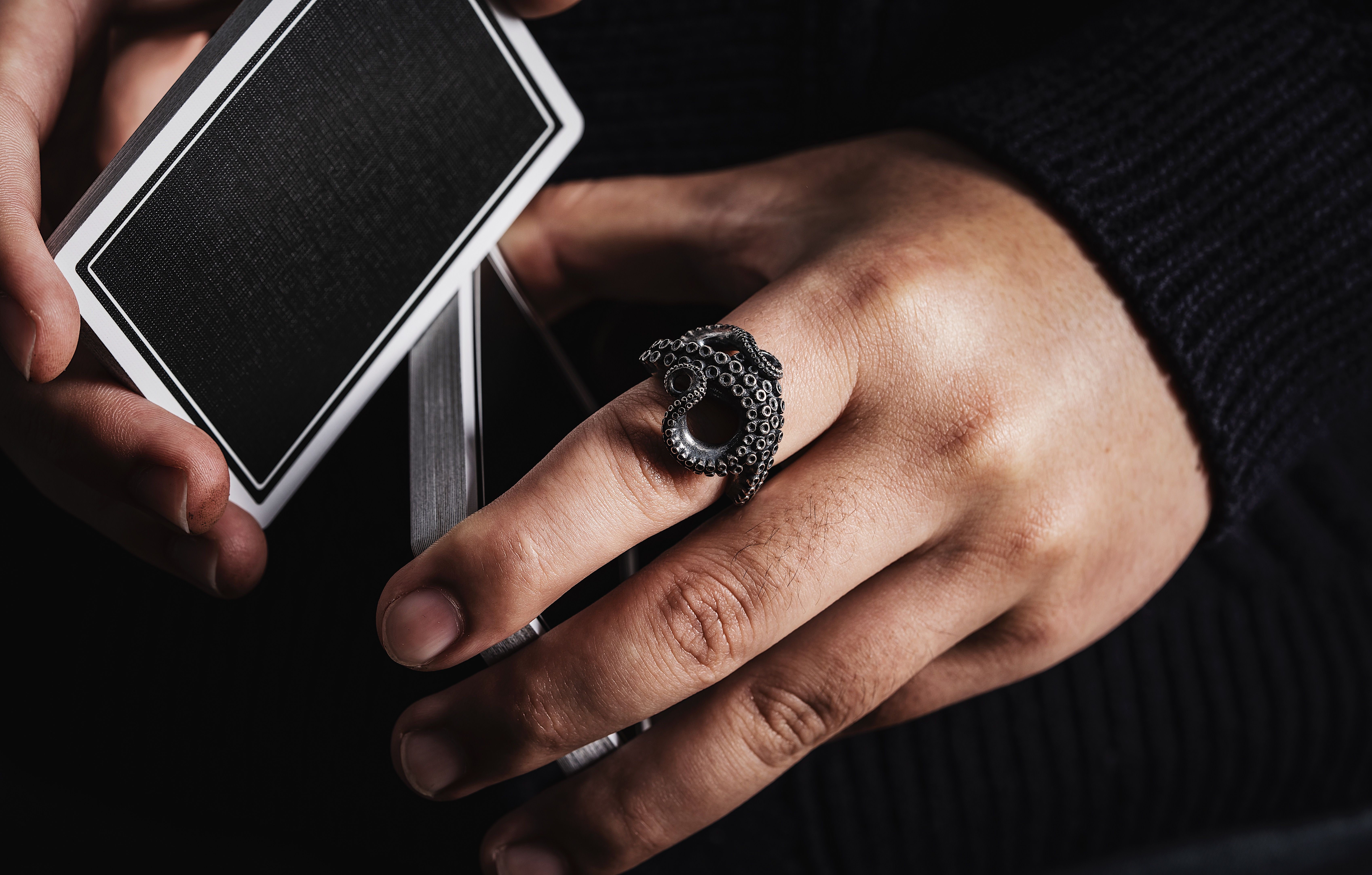 Close-up of Man Wearing an Octopus Tentacle Ring and Holding Cards ...
