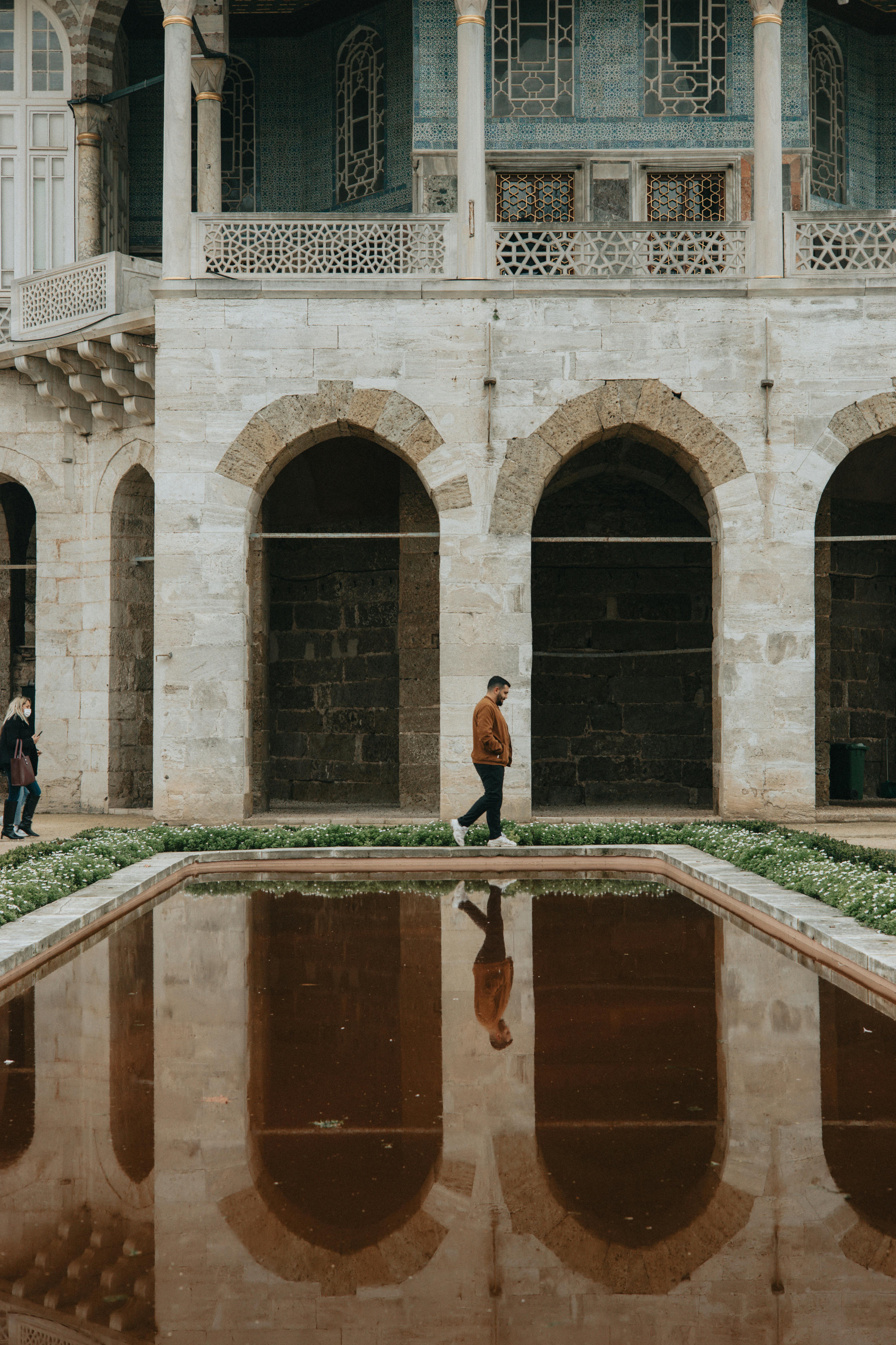 Man Walking near Water Pond in Topkapi Palace · Free Stock Photo