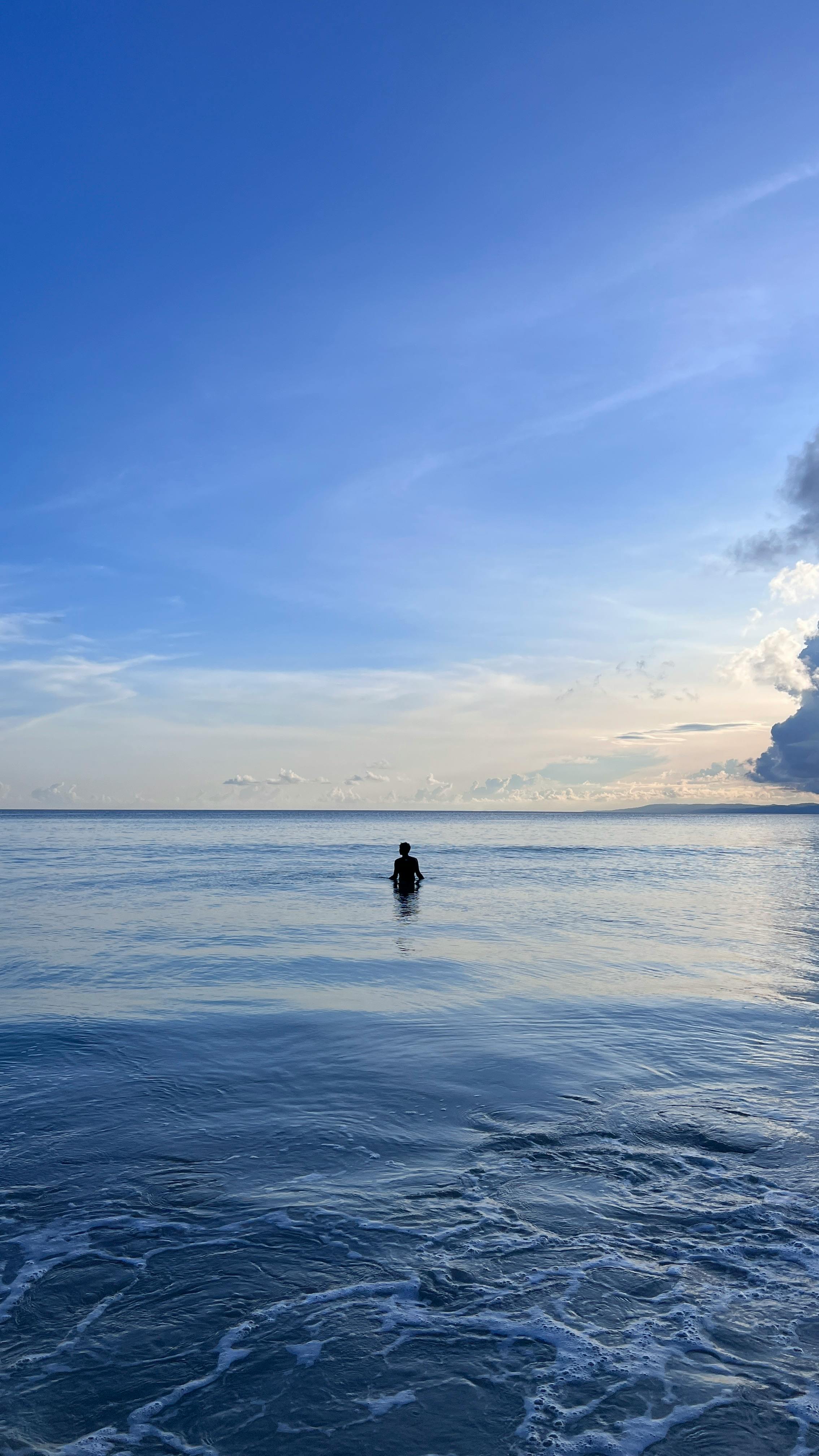 Person Standing in Water on Shore · Free Stock Photo