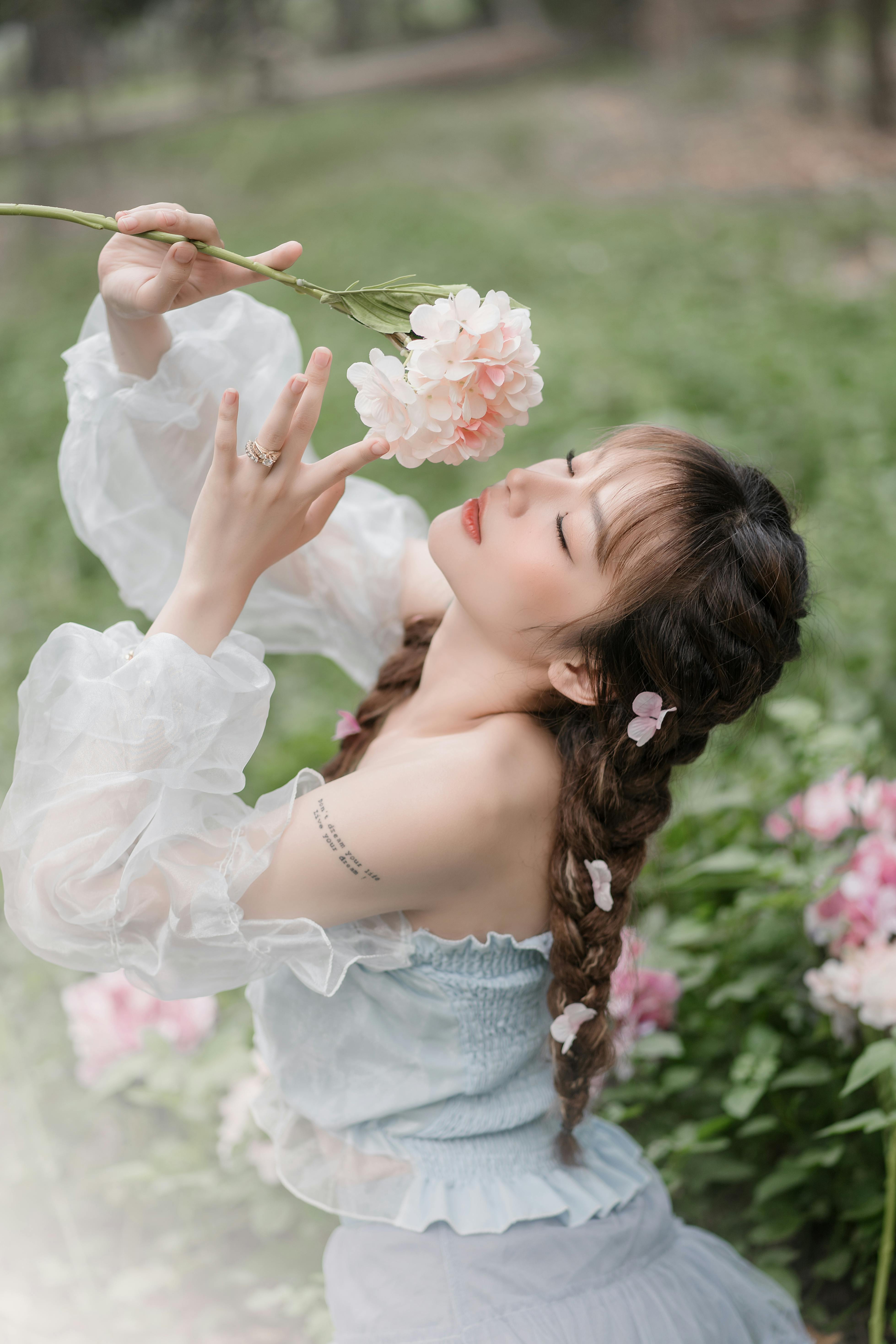 Woman Smelling a Flower · Free Stock Photo
