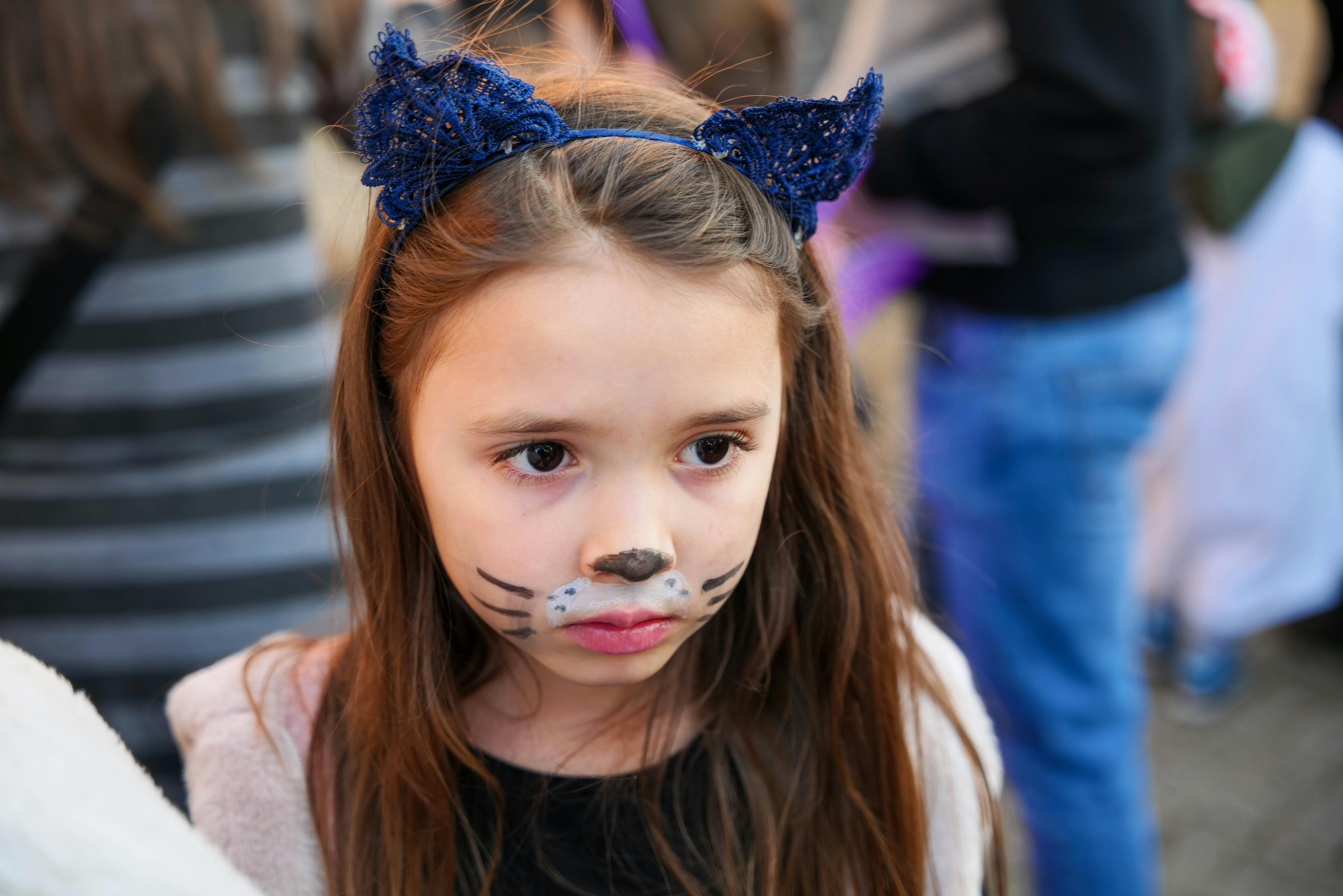 A Little Girl Wearing Cat Ears and a Cat Face Painting · Free Stock Photo