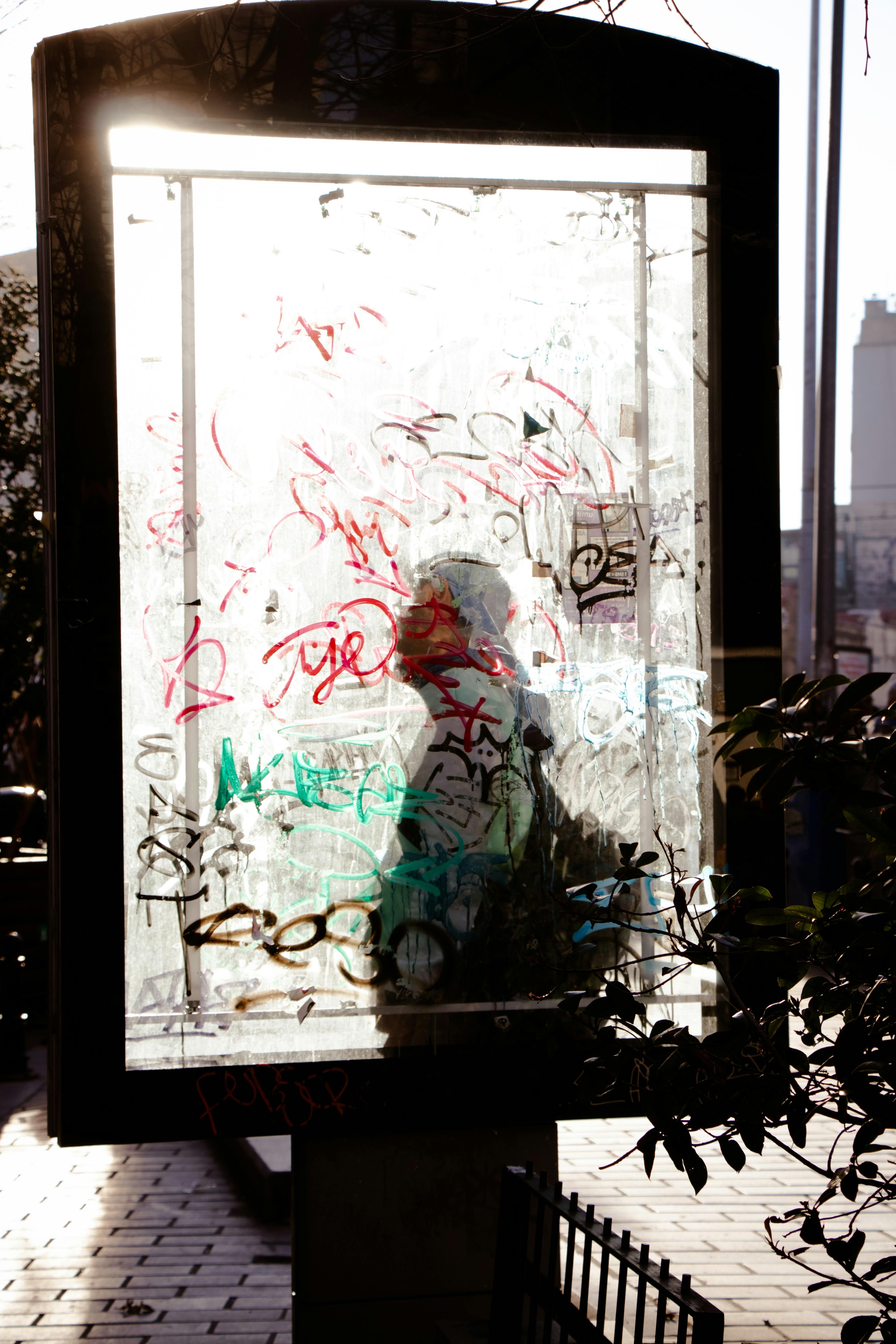 Person Standing behind Graffiti on Window · Free Stock Photo