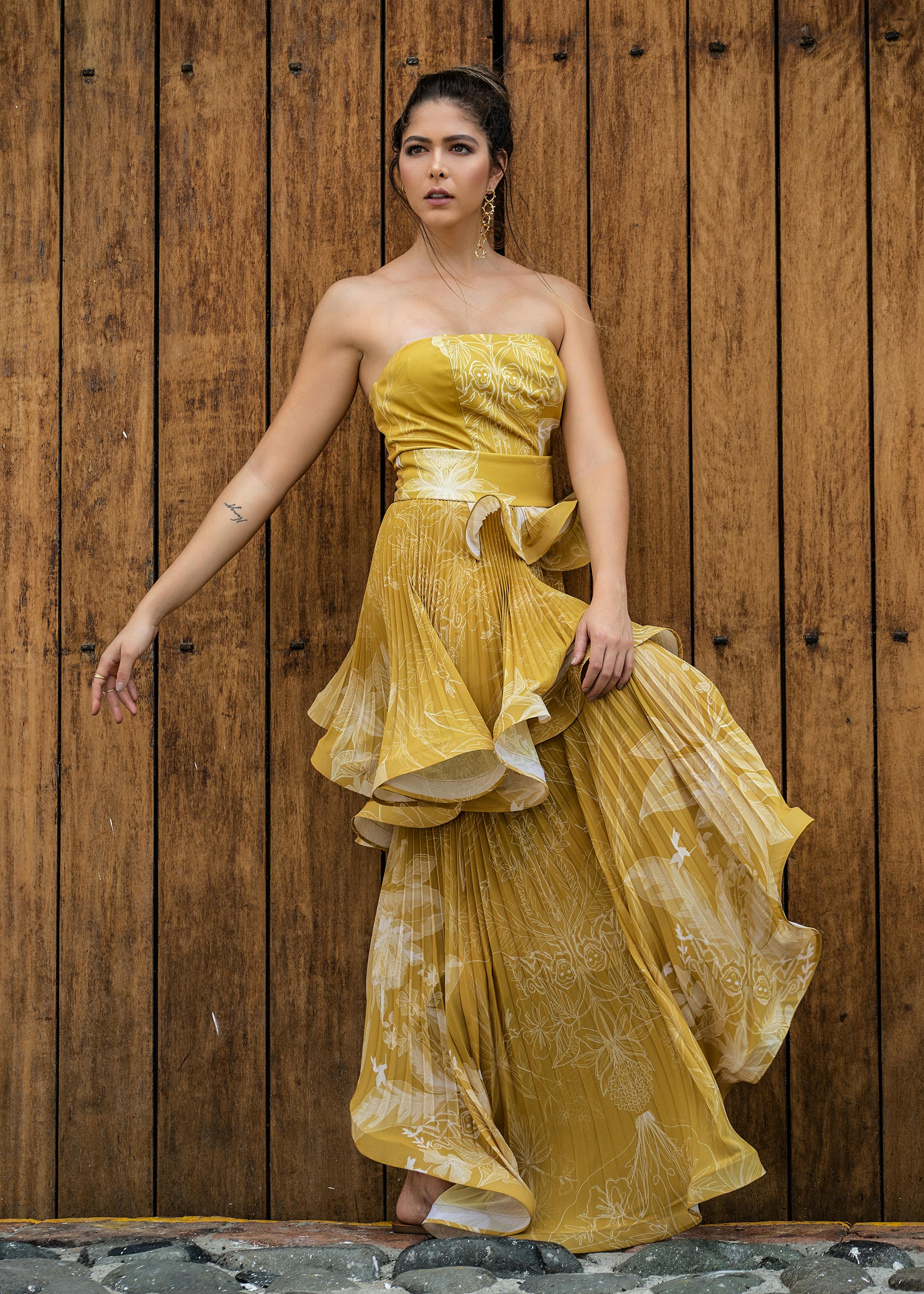 Female Model Wearing a Yellow Dress Posing in Front of a Wooden Wall ...