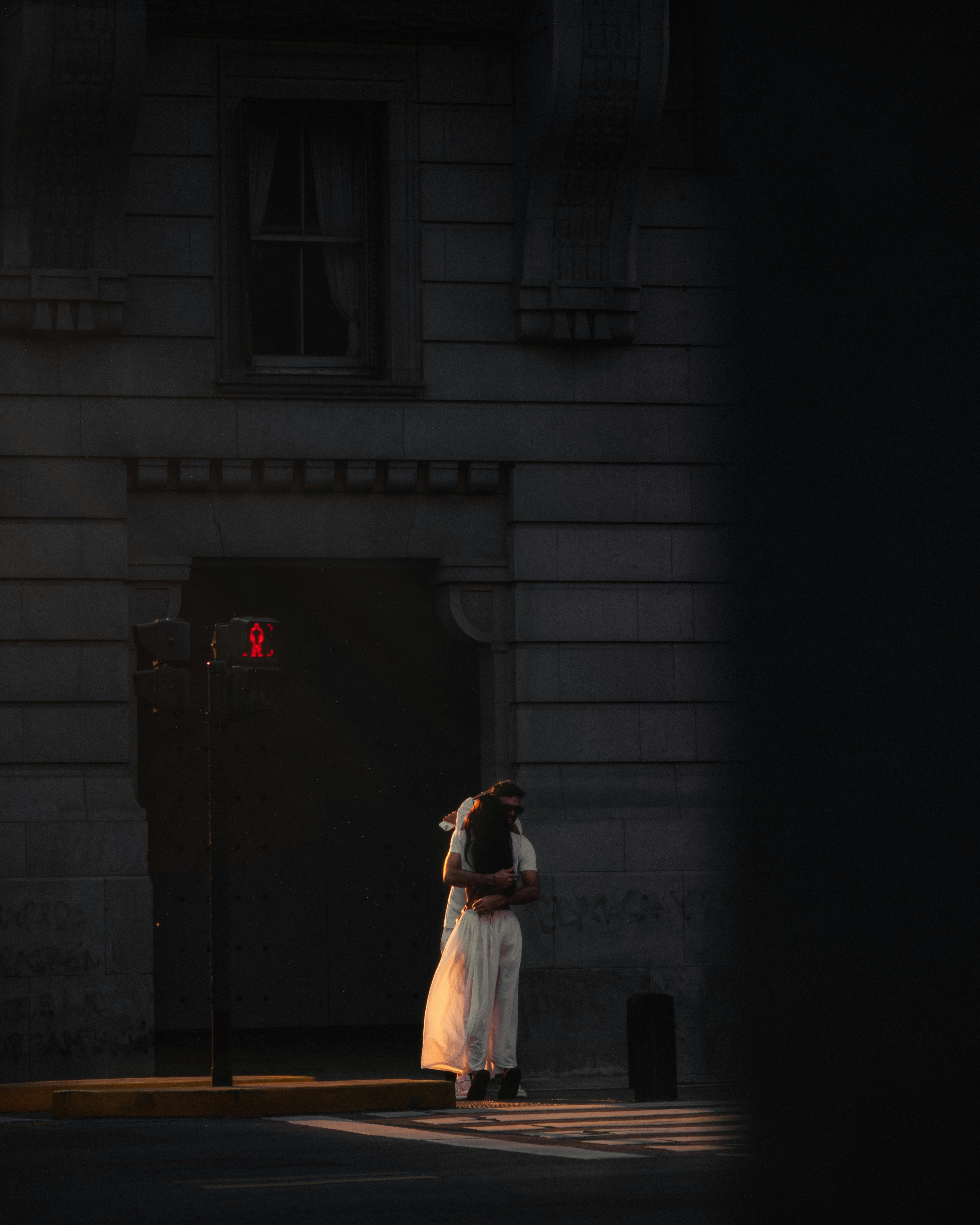 Couple Hugging by Building Wall · Free Stock Photo