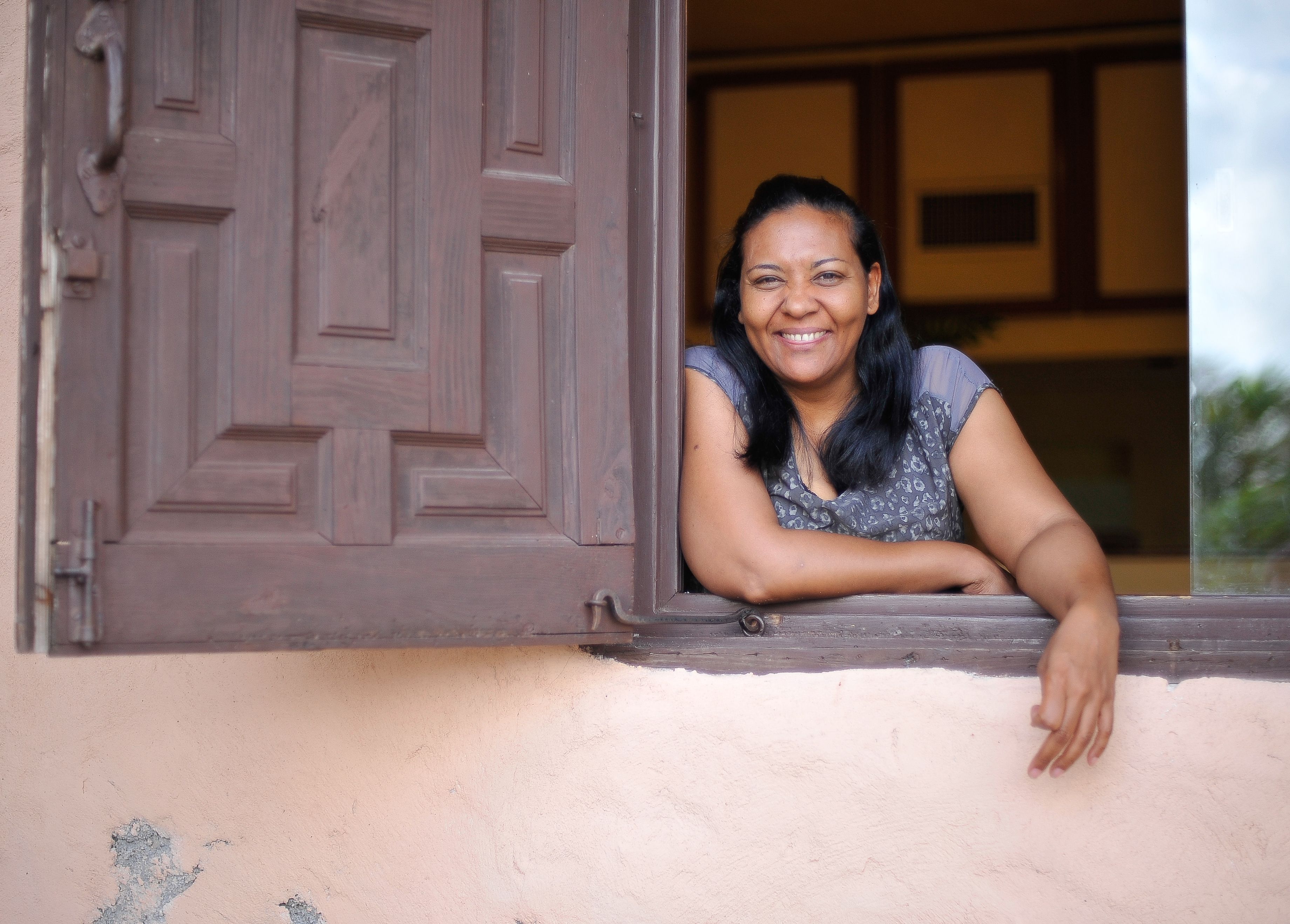 Smiling Woman in Opened Window · Free Stock Photo