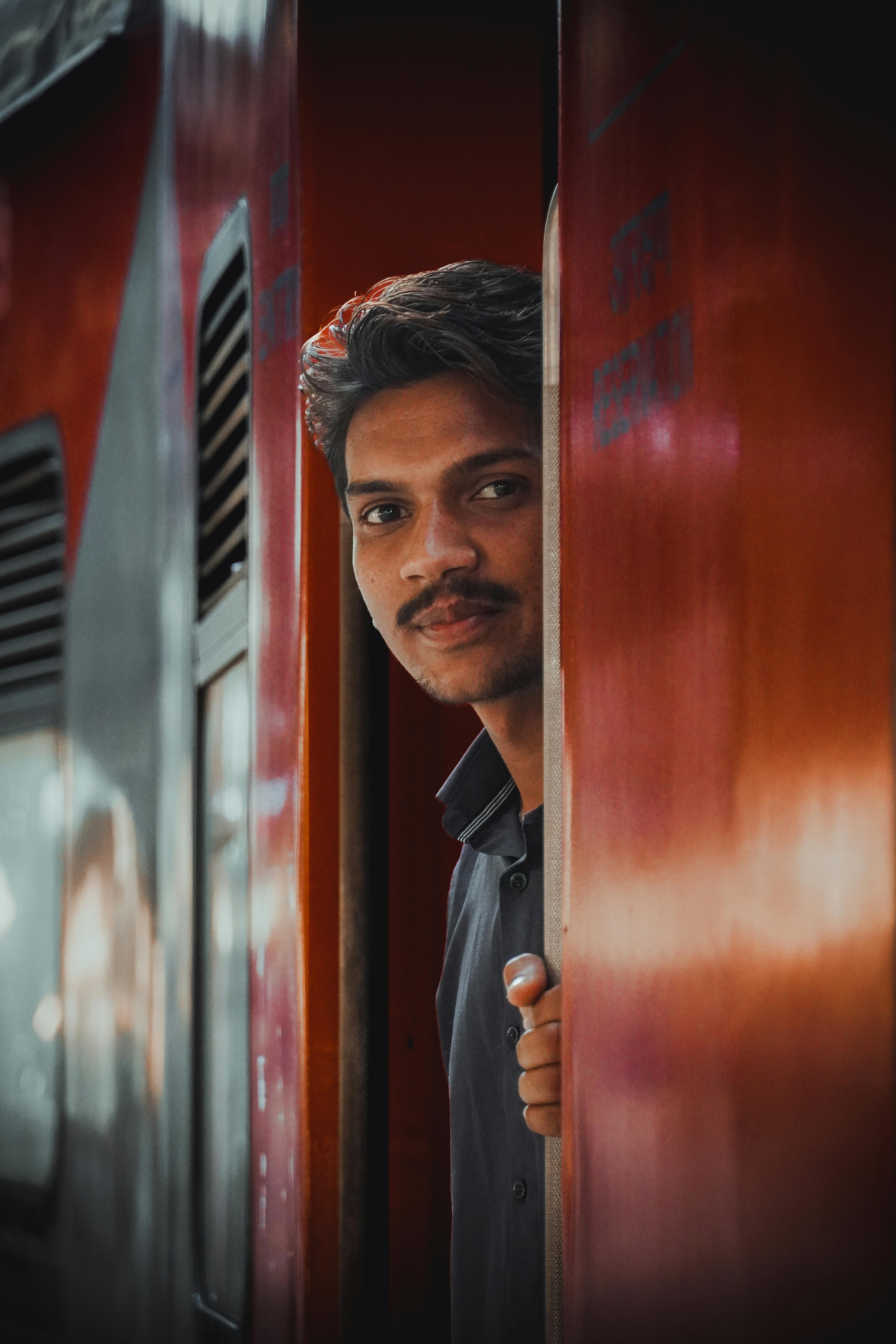 Man with Mustache Standing in a Train Doorway · Free Stock Photo