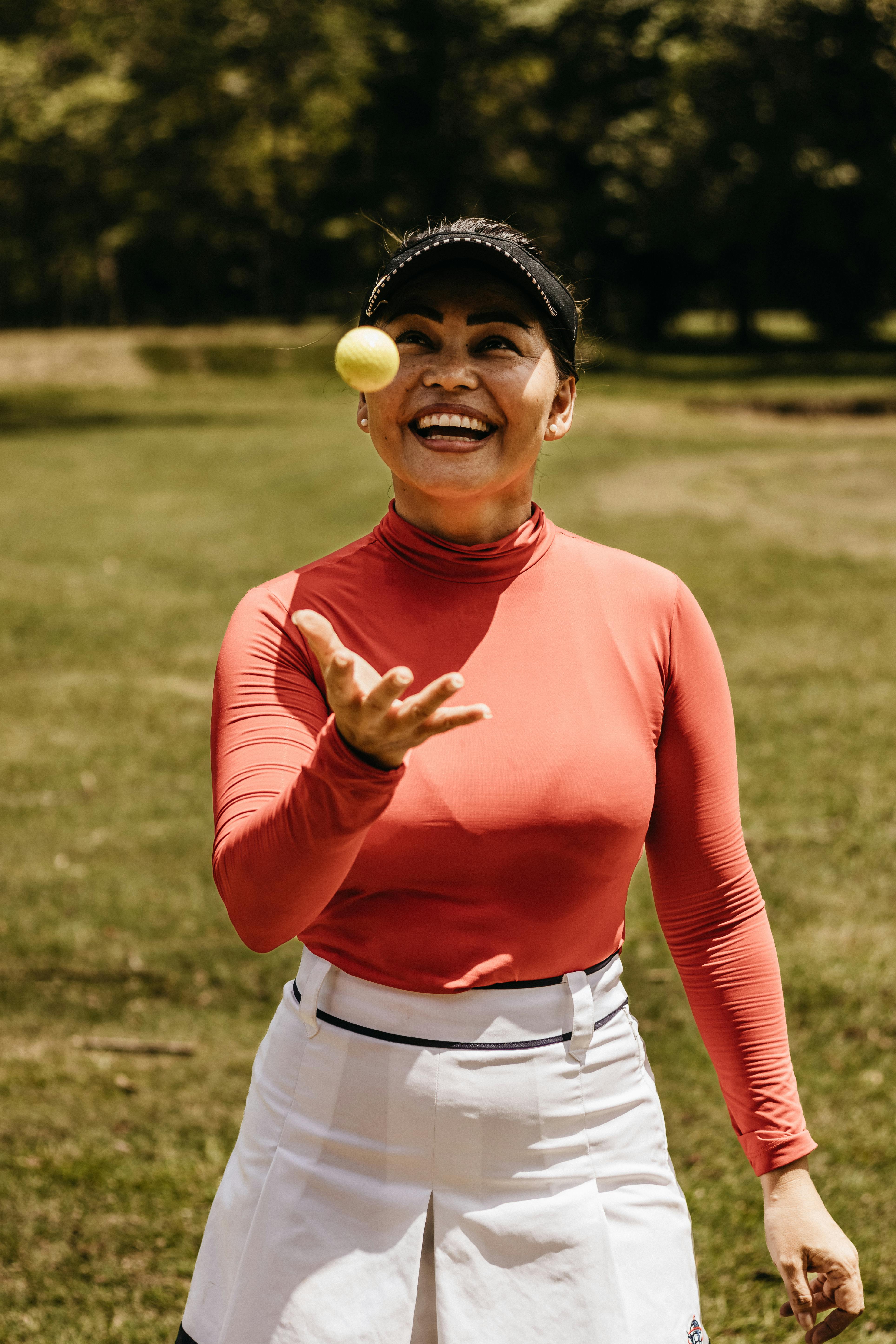Smiling Woman Throwing Golf Ball · Free Stock Photo
