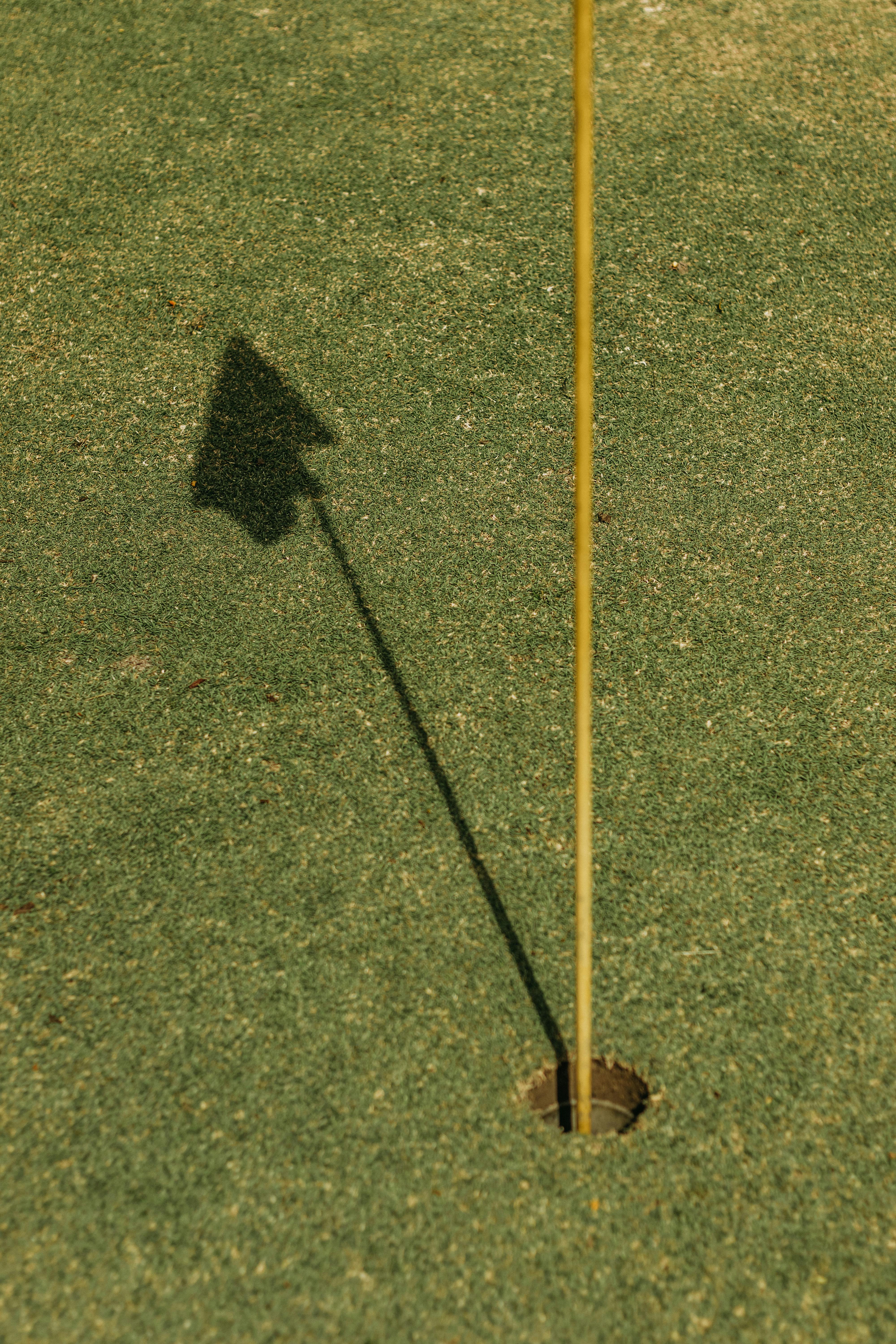 Flagstick Shadow on Golf Course Lawn · Free Stock Photo