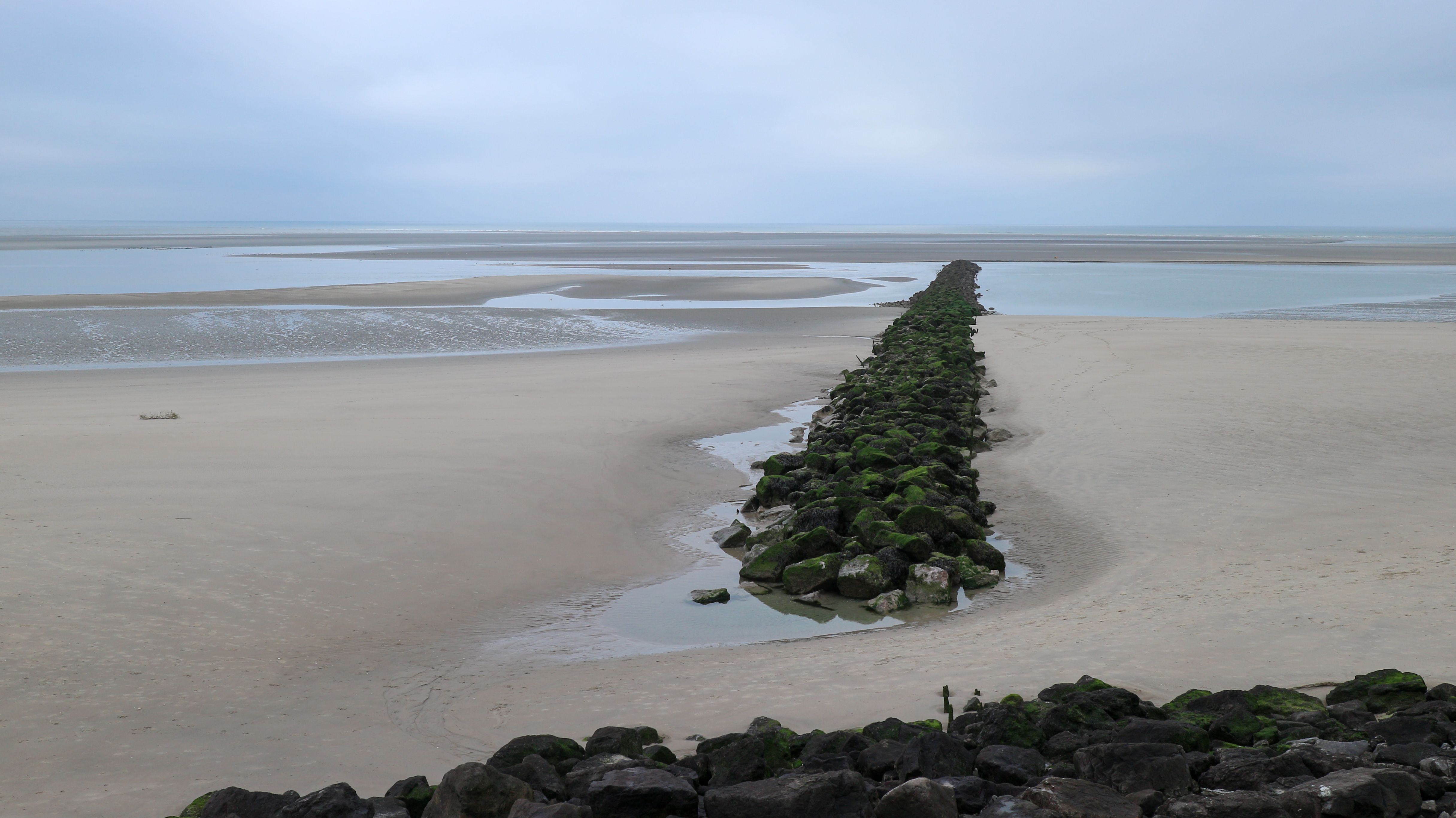 Sandy Beach with Rocky Breakwater · Free Stock Photo