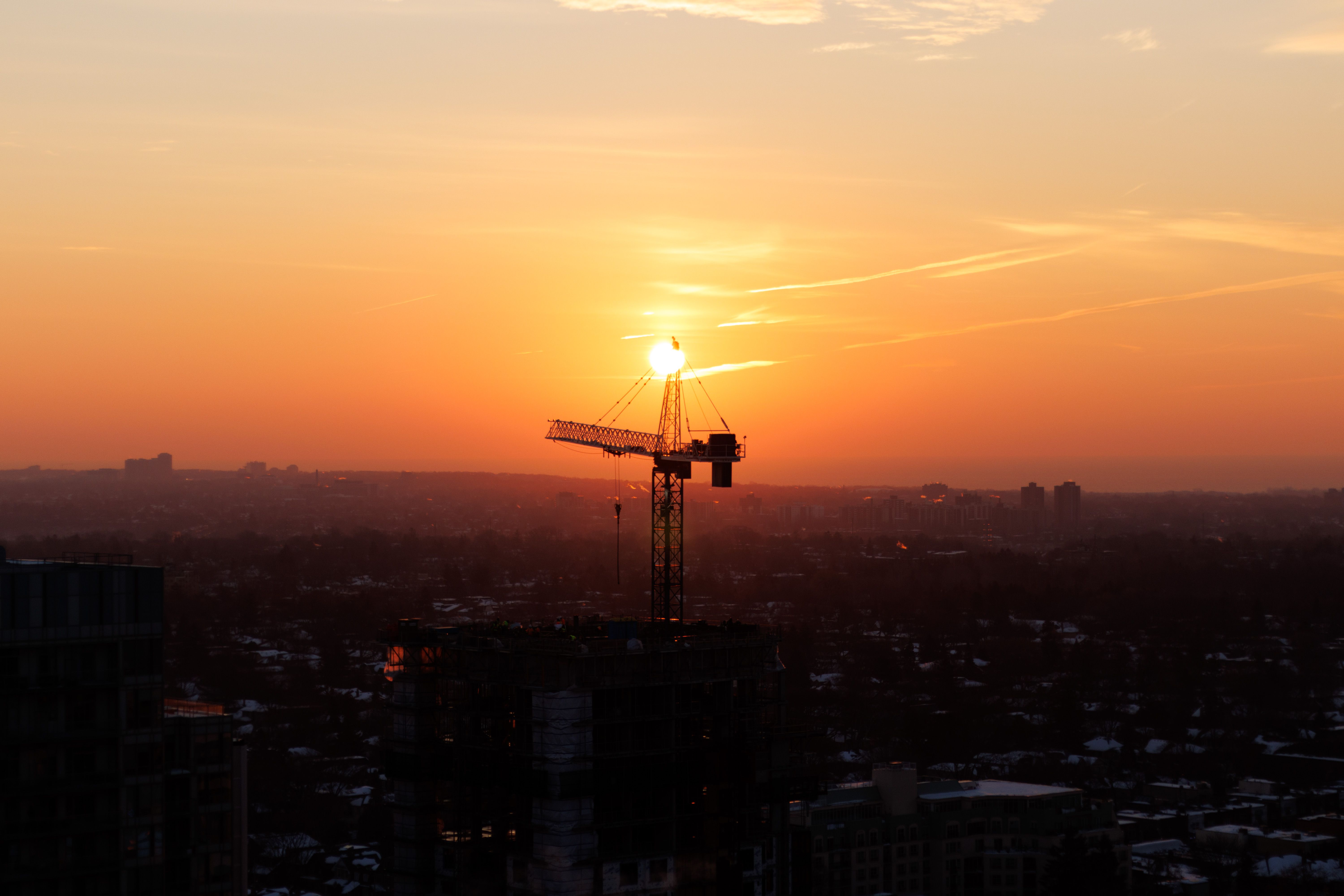 Construction Crane over Buildings at Sunset · Free Stock Photo