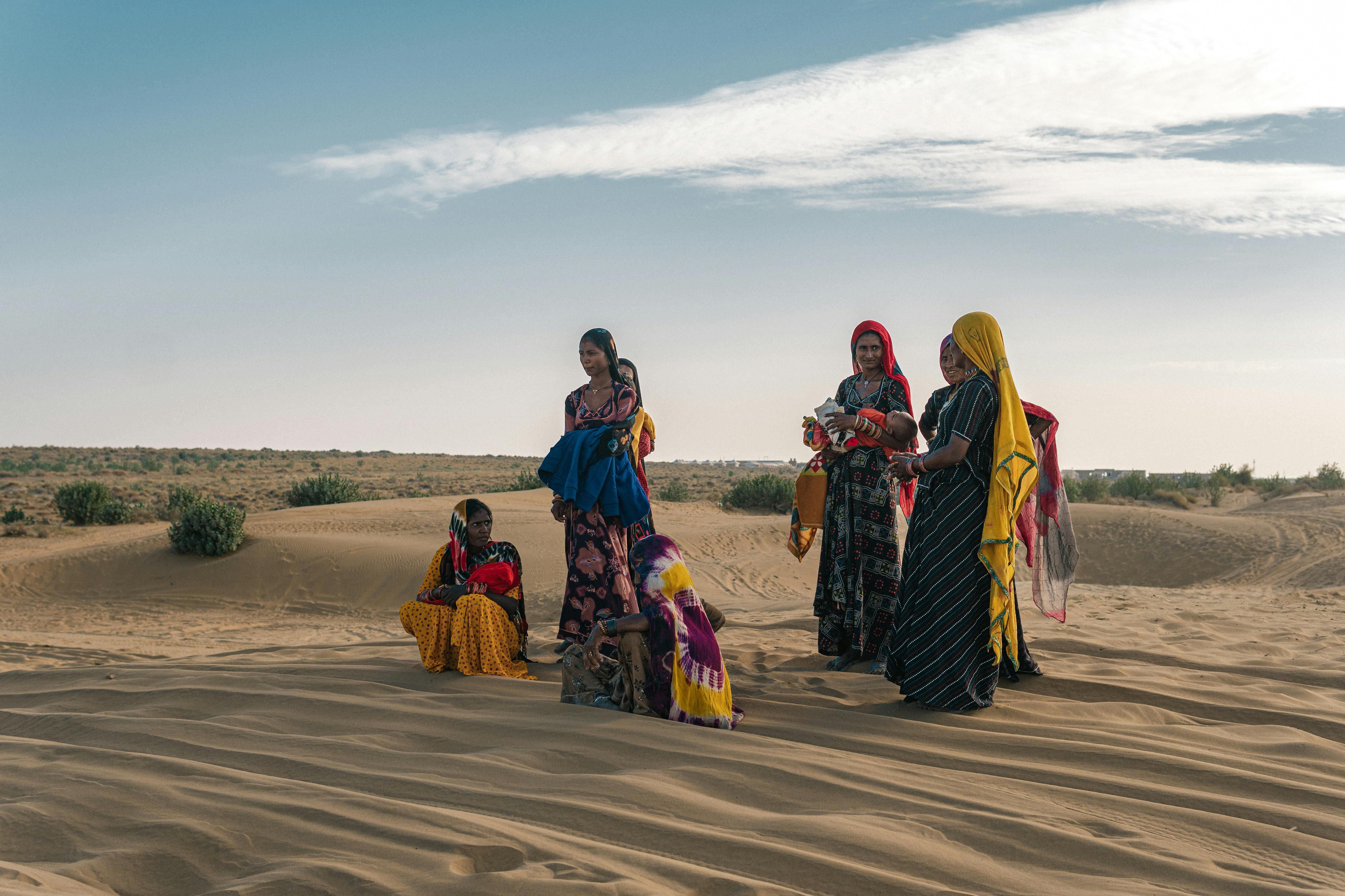 A Group of Women in Traditional Clothing on a Desert · Free Stock Photo