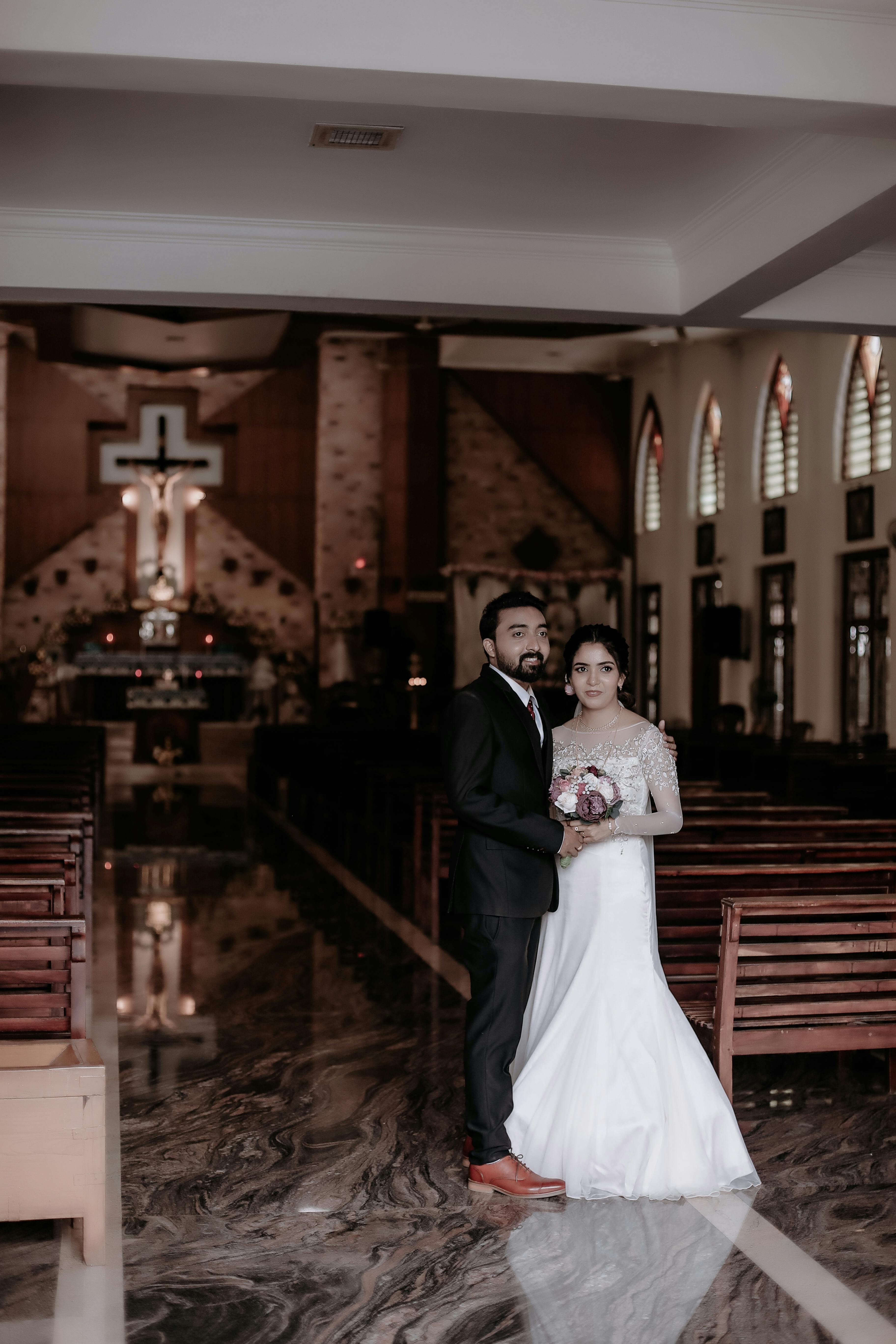 Newlywed Couple Standing and Posing in a Church · Free Stock Photo