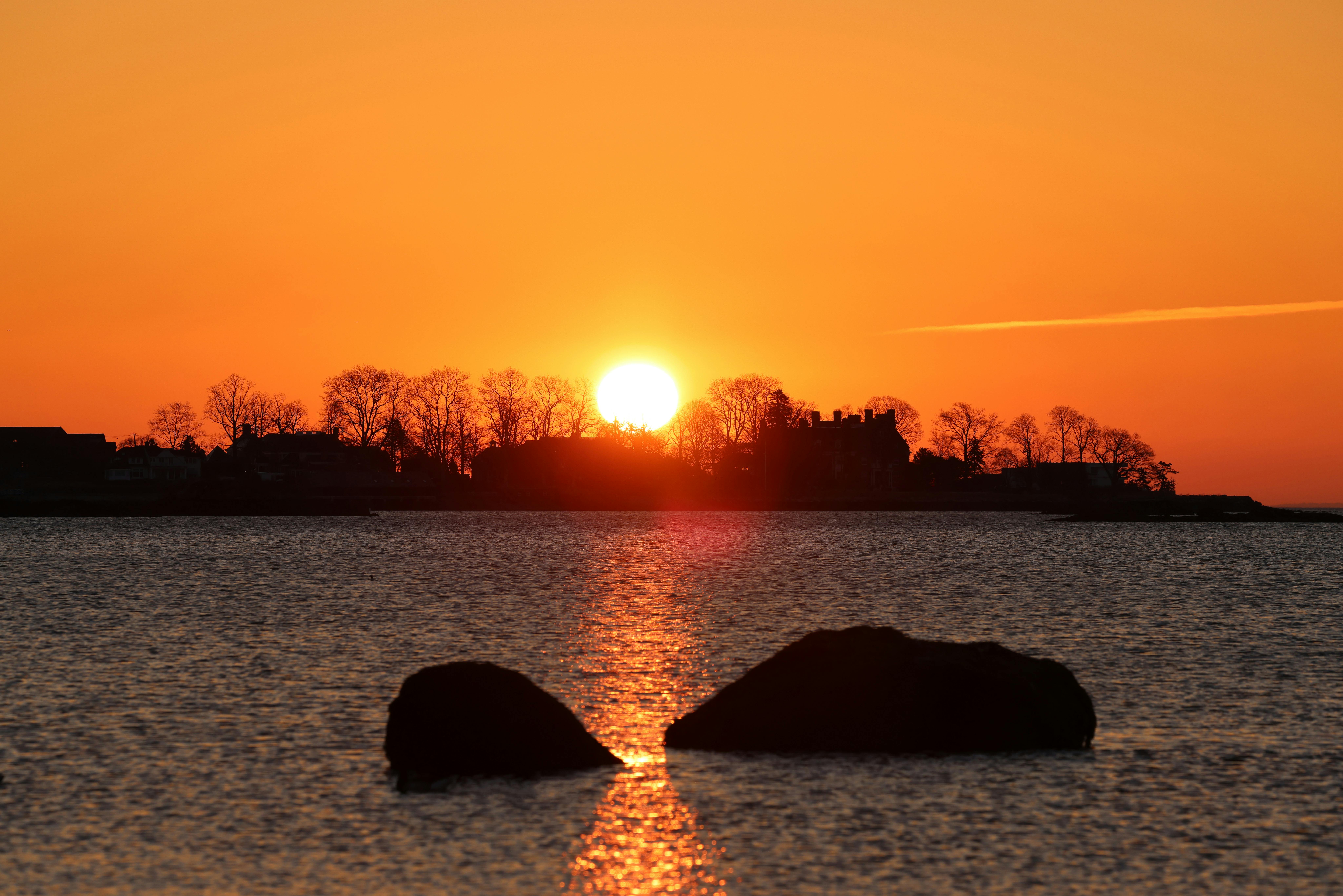 Setting Sun over the Houses of a Seaside Town · Free Stock Photo