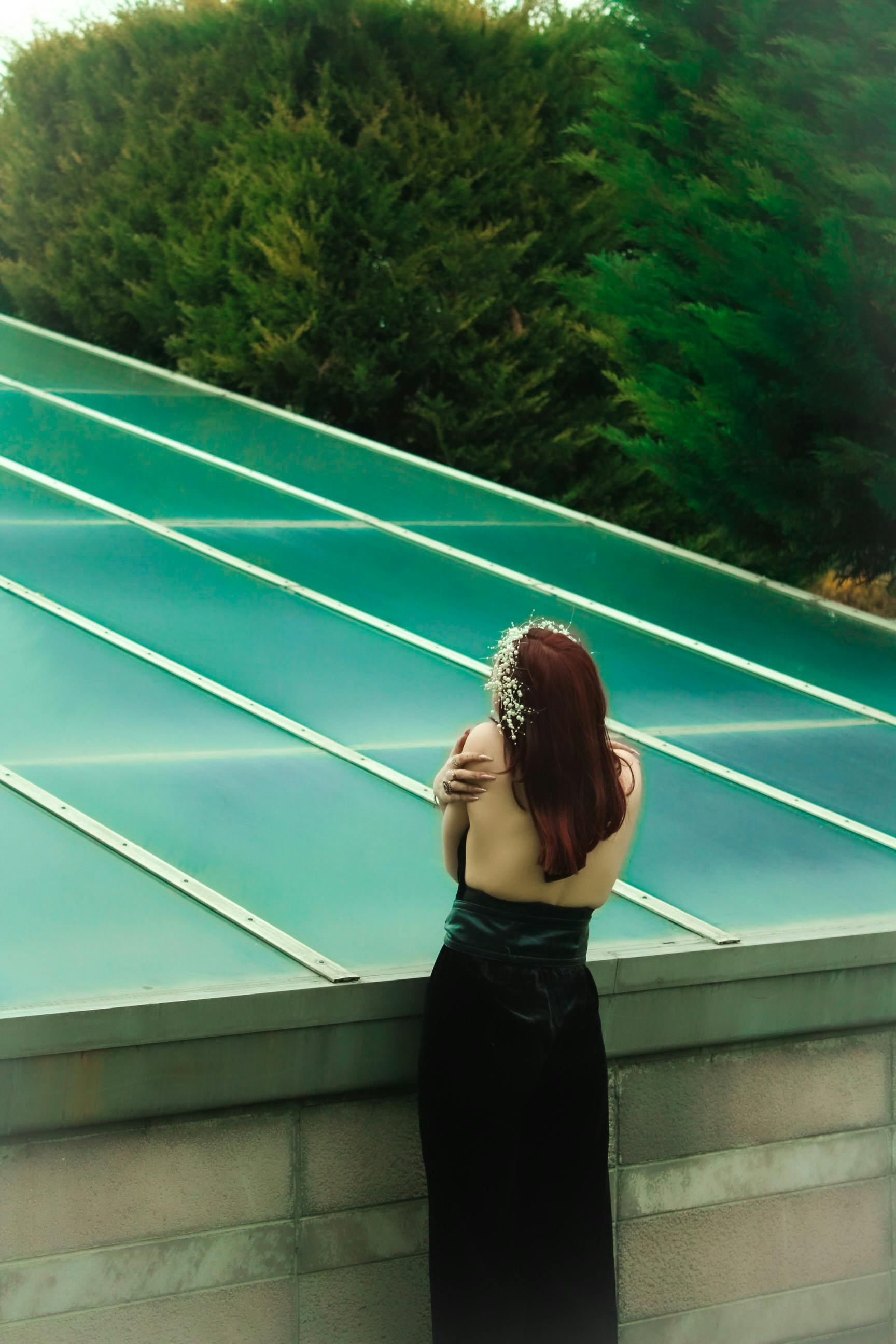 Woman in Sundress Sitting on Wooden Boardwalk Railing · Free Stock Photo