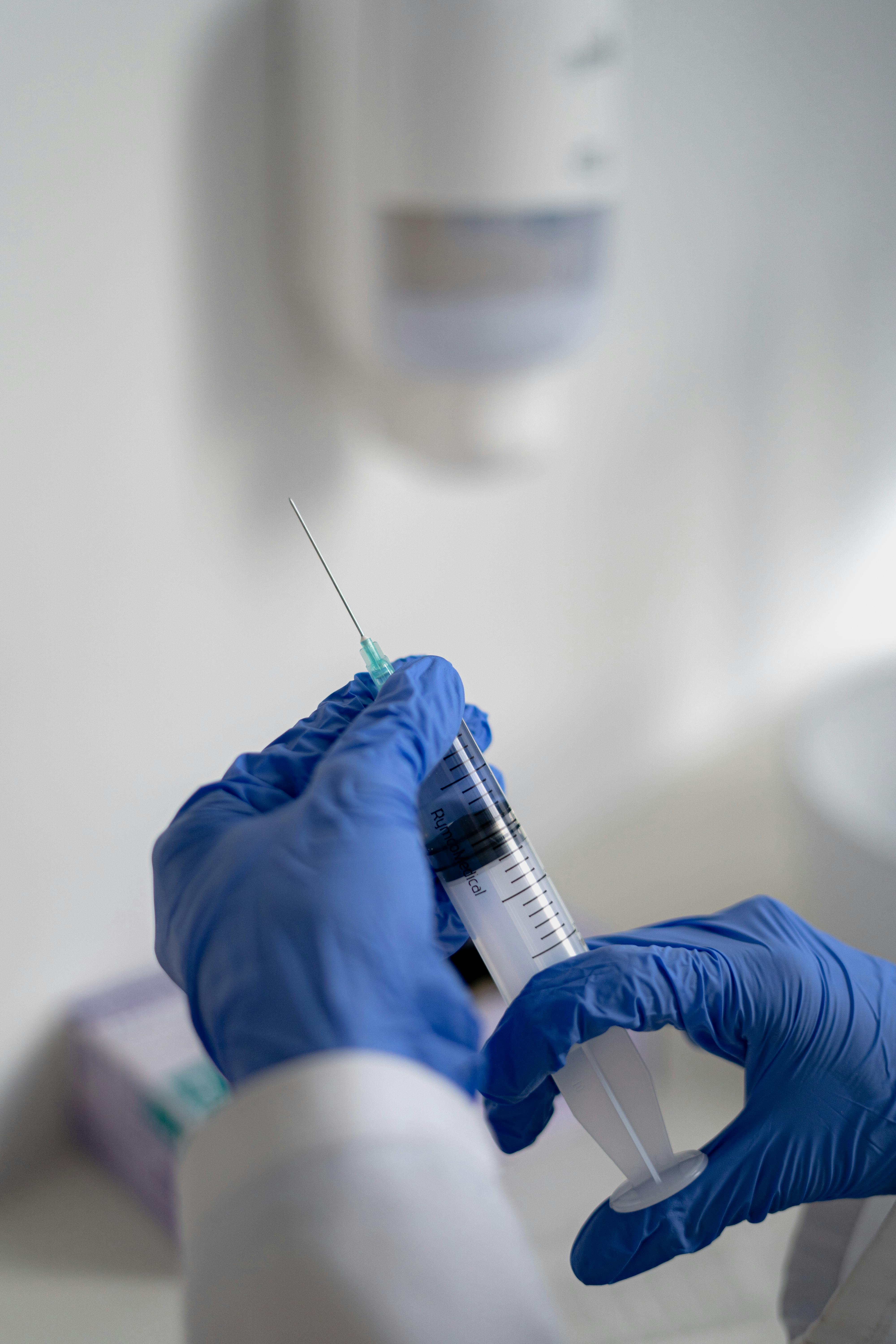 A Person Holding a Syringe · Free Stock Photo