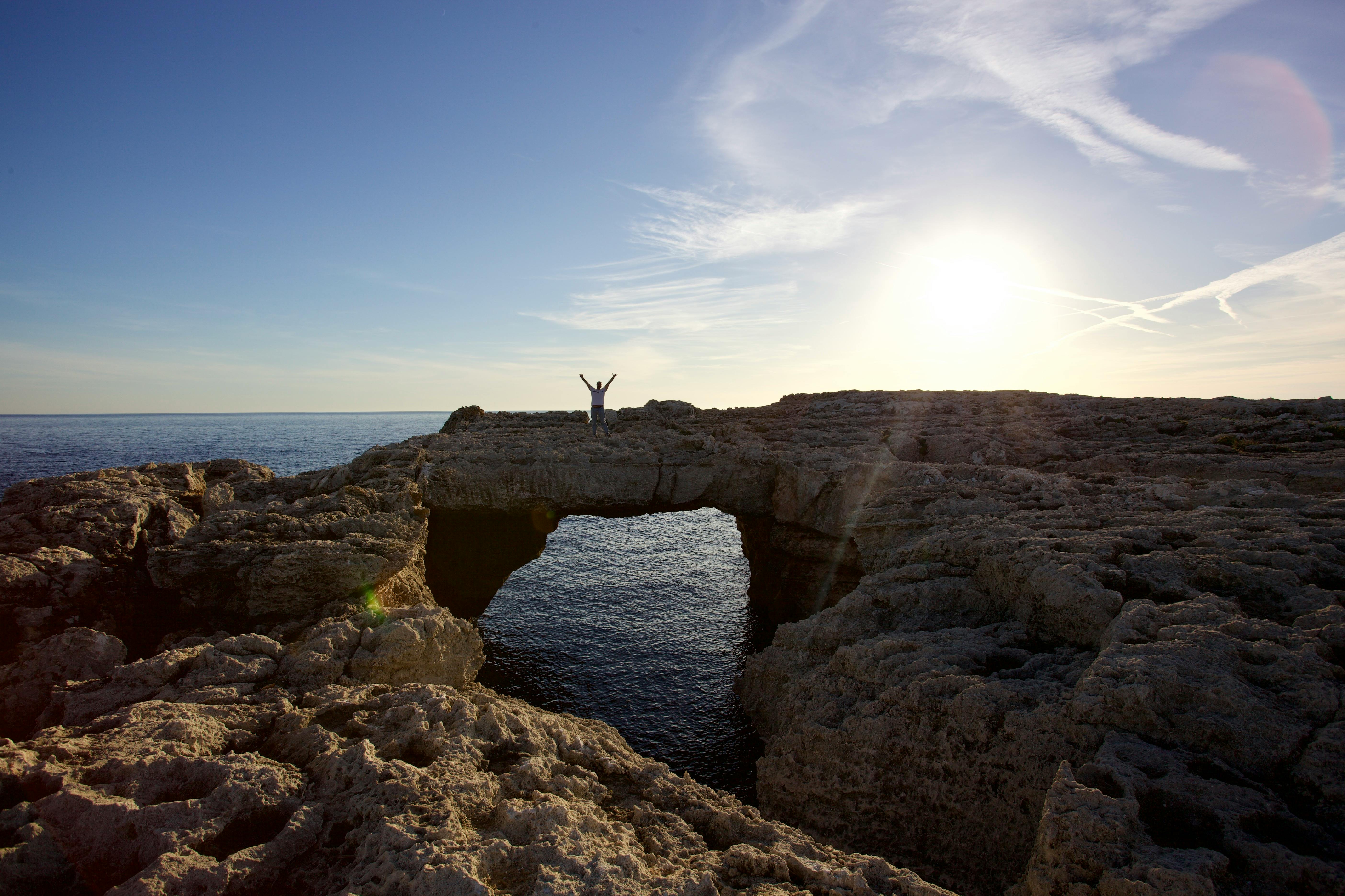 Man Standing on the Natural Arch over the Sea · Free Stock Photo