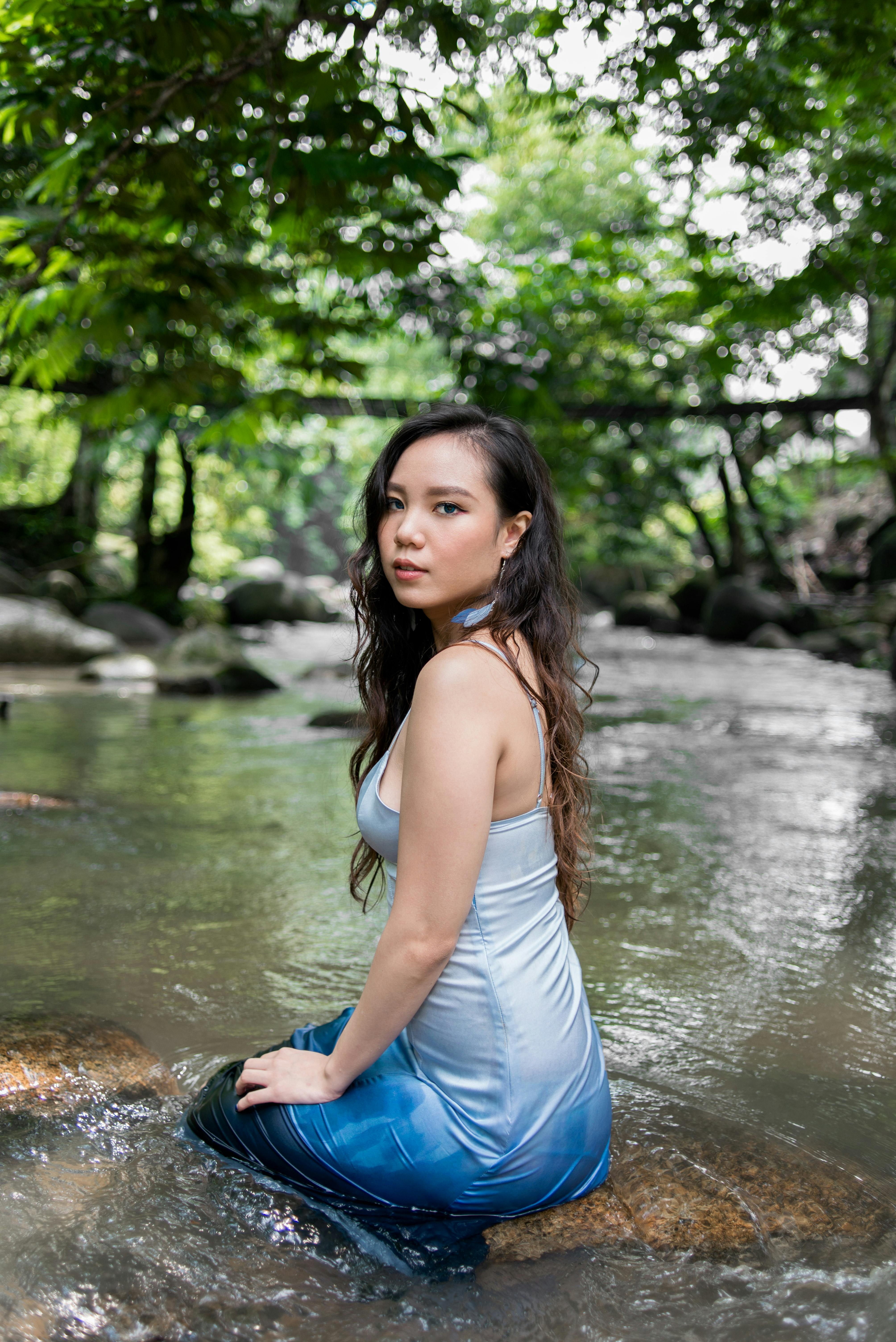 Woman in Red String Spaghetti Strap Dress on Body of Water Near Forest ...