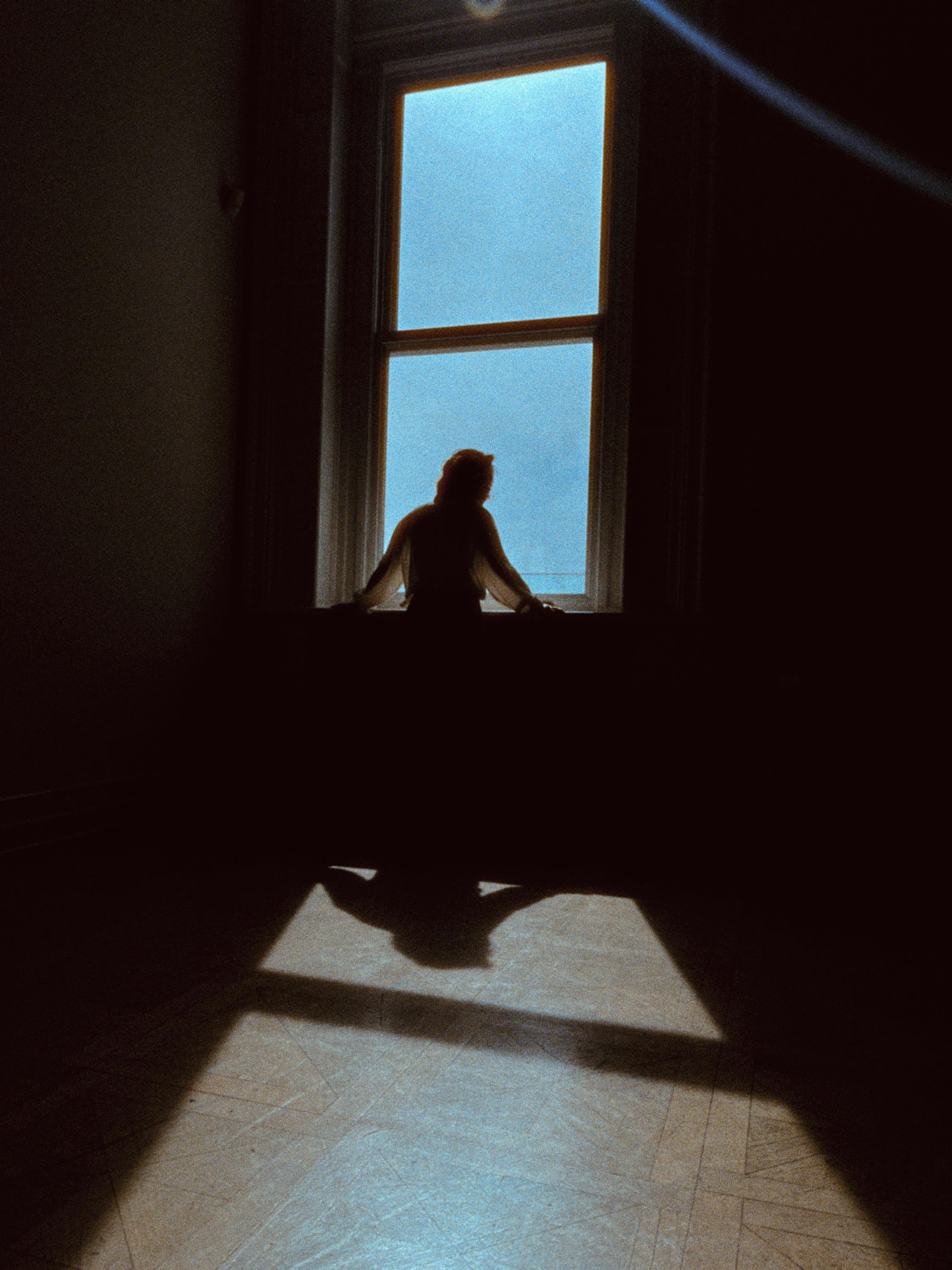 Person Standing by Sunlit Windows · Free Stock Photo